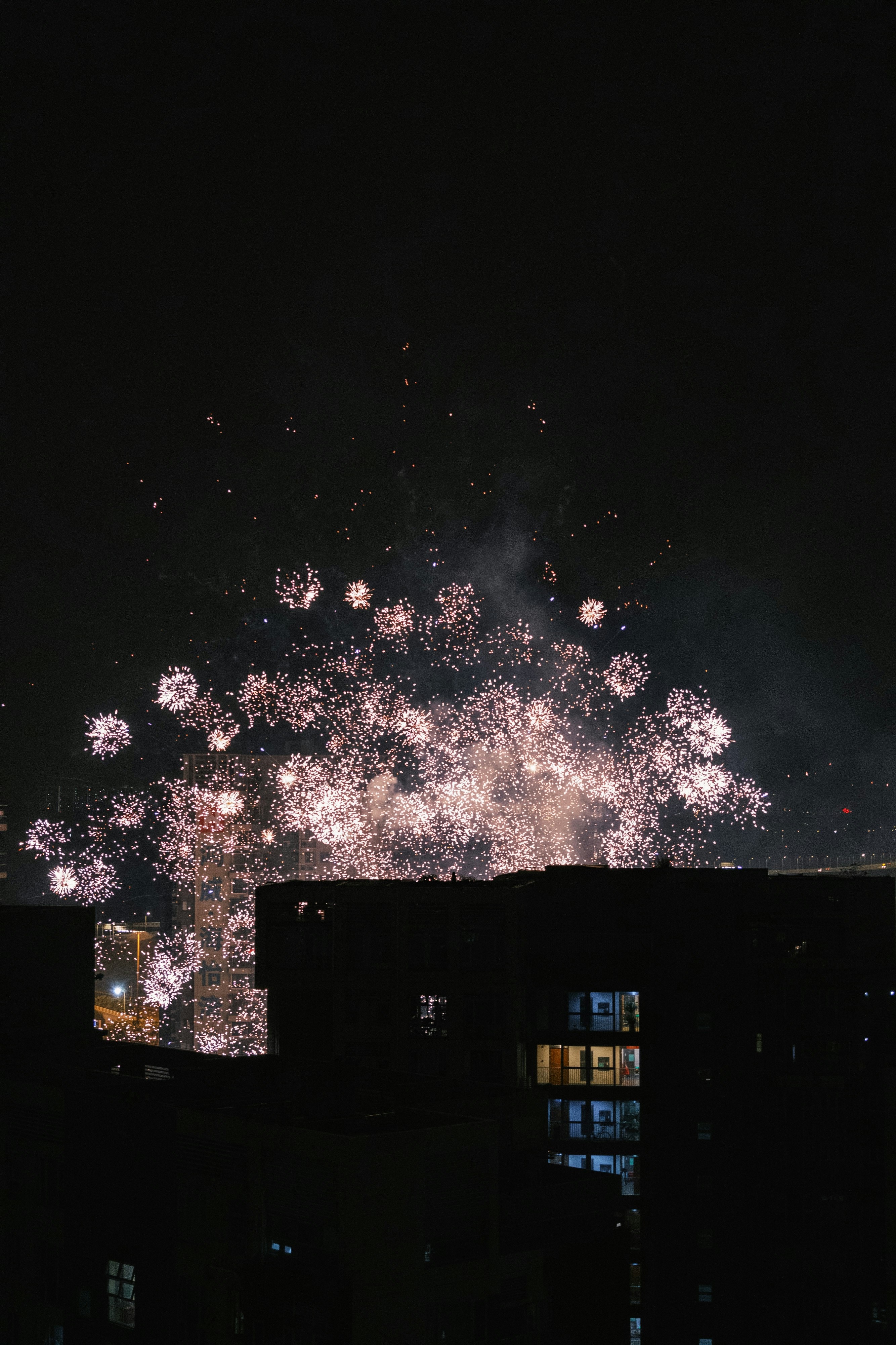 Fireworks are lit up in the night sky above a city photo – Free ...