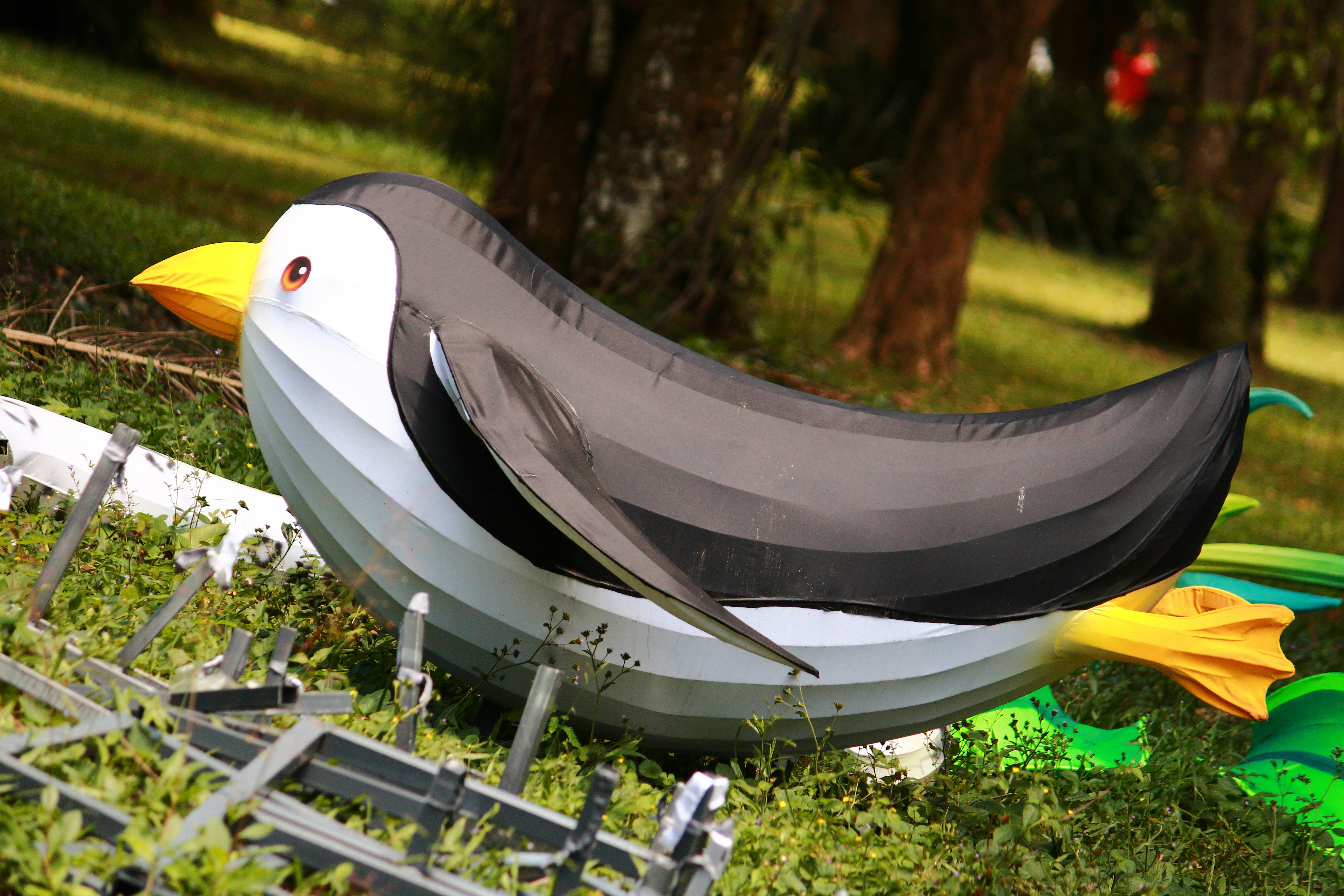 Giant Inflatable Penguin Pauses by Park Rails