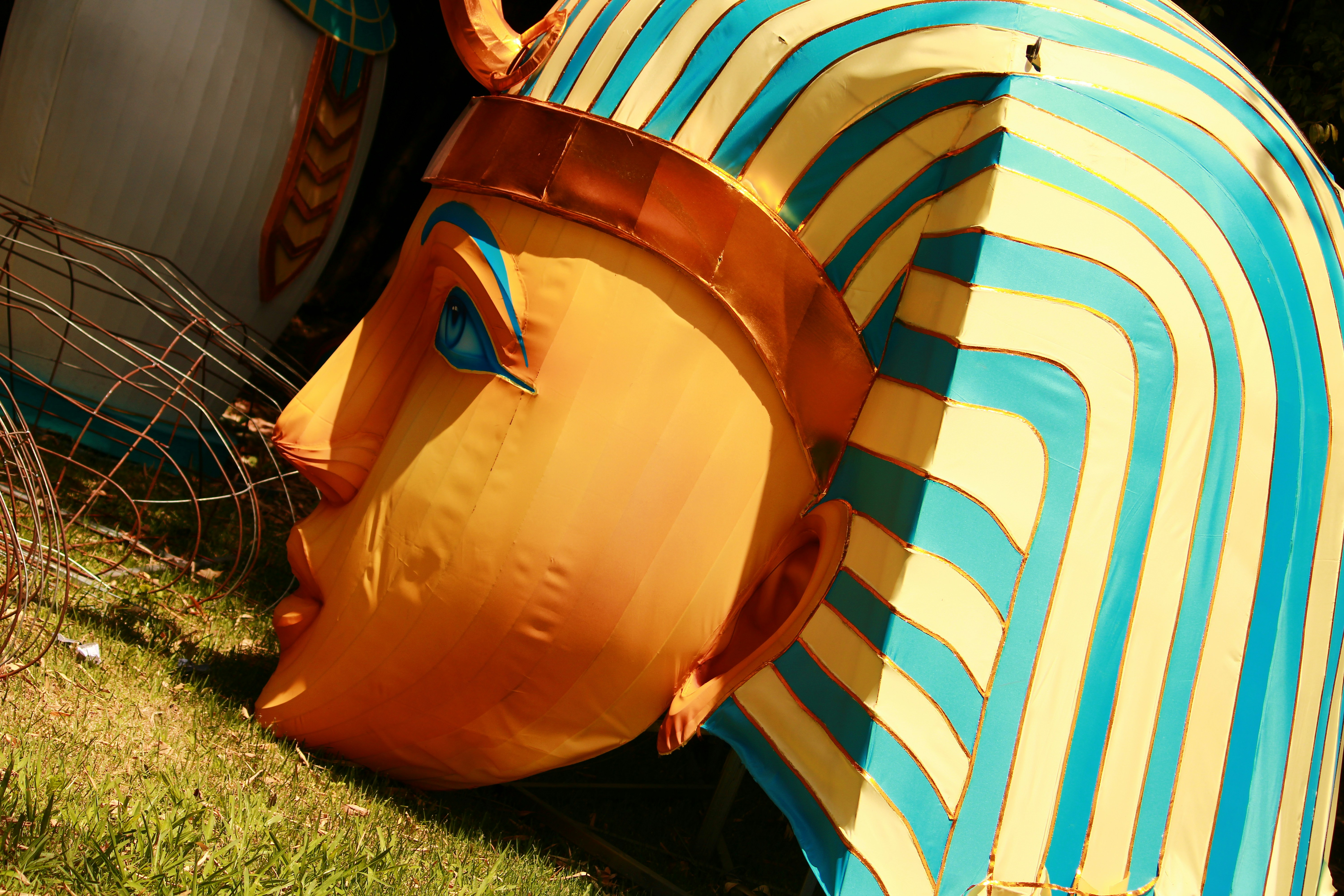 Tilted Pharaoh Head: An Orange Inflatable with a Striped Turquoise-and-Yellow Headdress