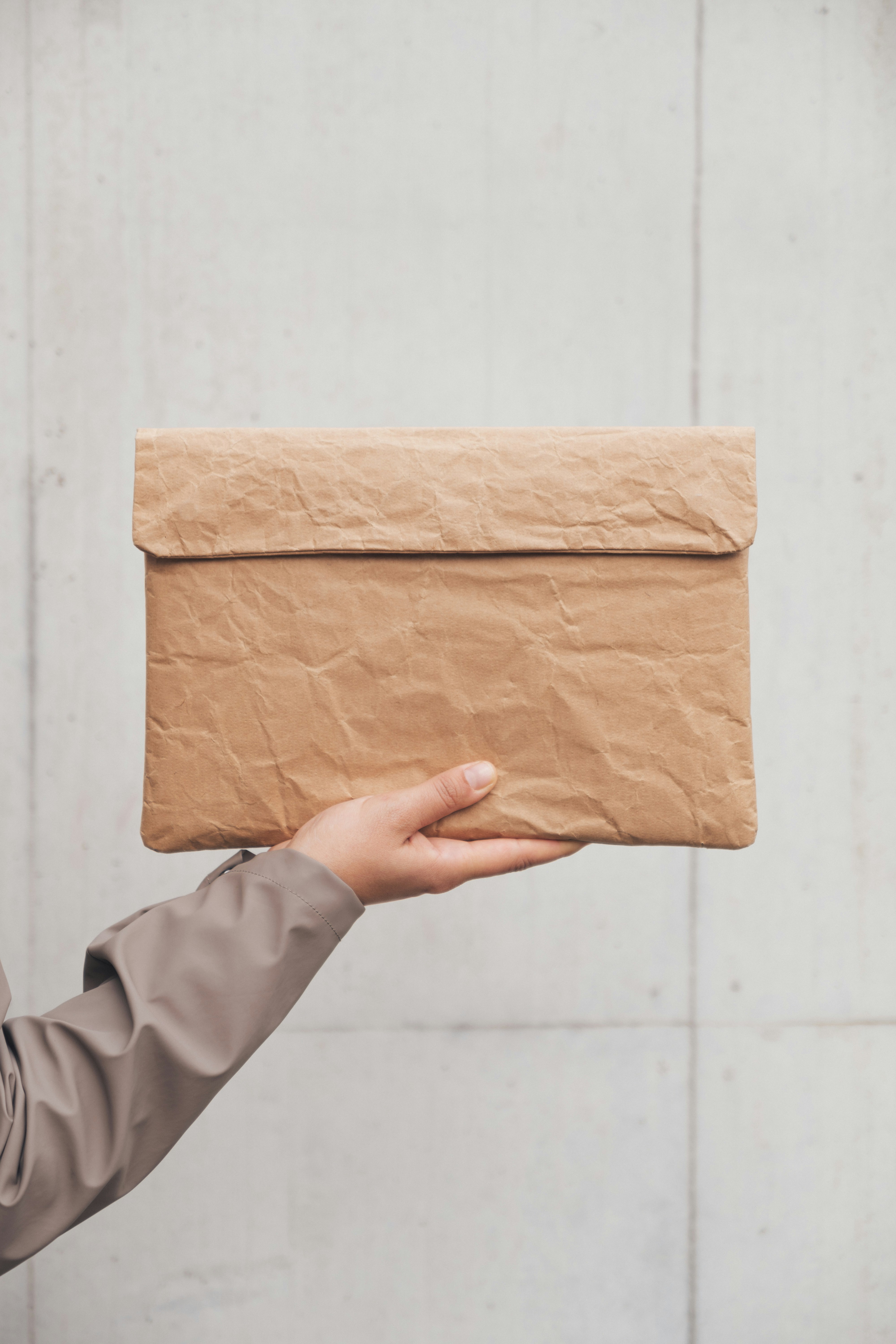 A woman holding a brown envelope over her face photo – Free Wren Image ...