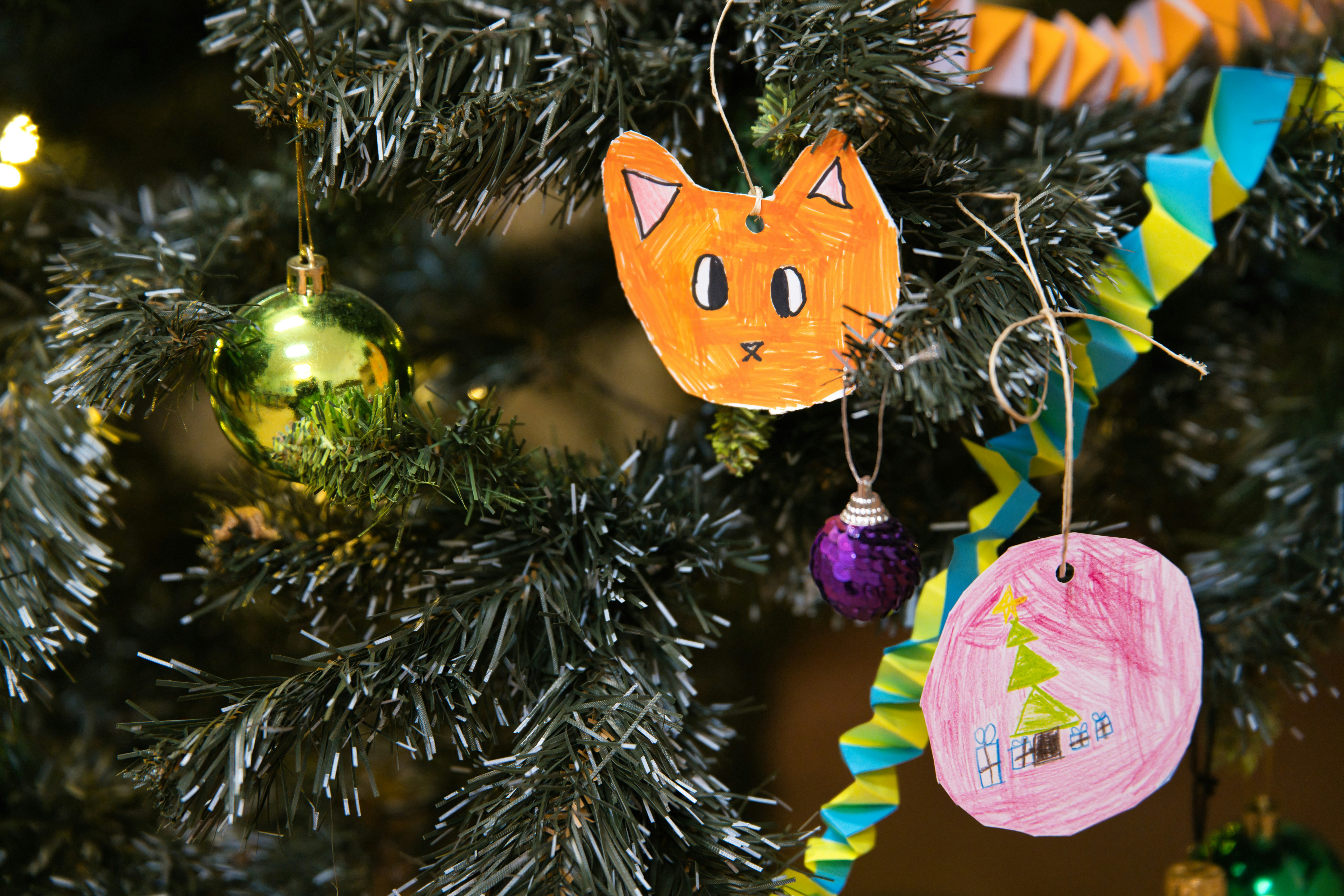 Hand-drawn Orange Cat Ornament Anchoring a Festive Christmas Tree Scene