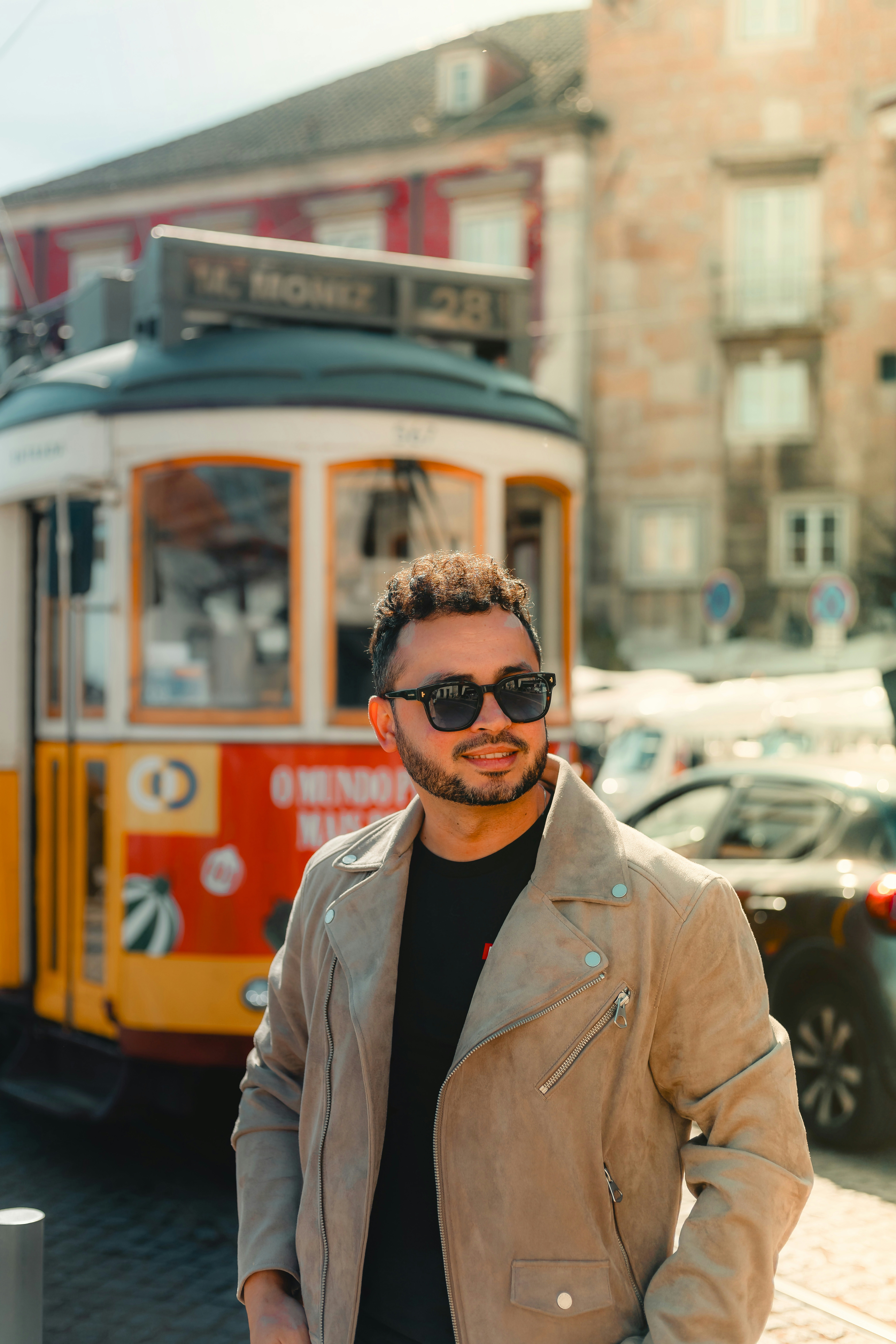 Streetwise Portrait: A Man in Sunglasses Against a Blurred Red Tram