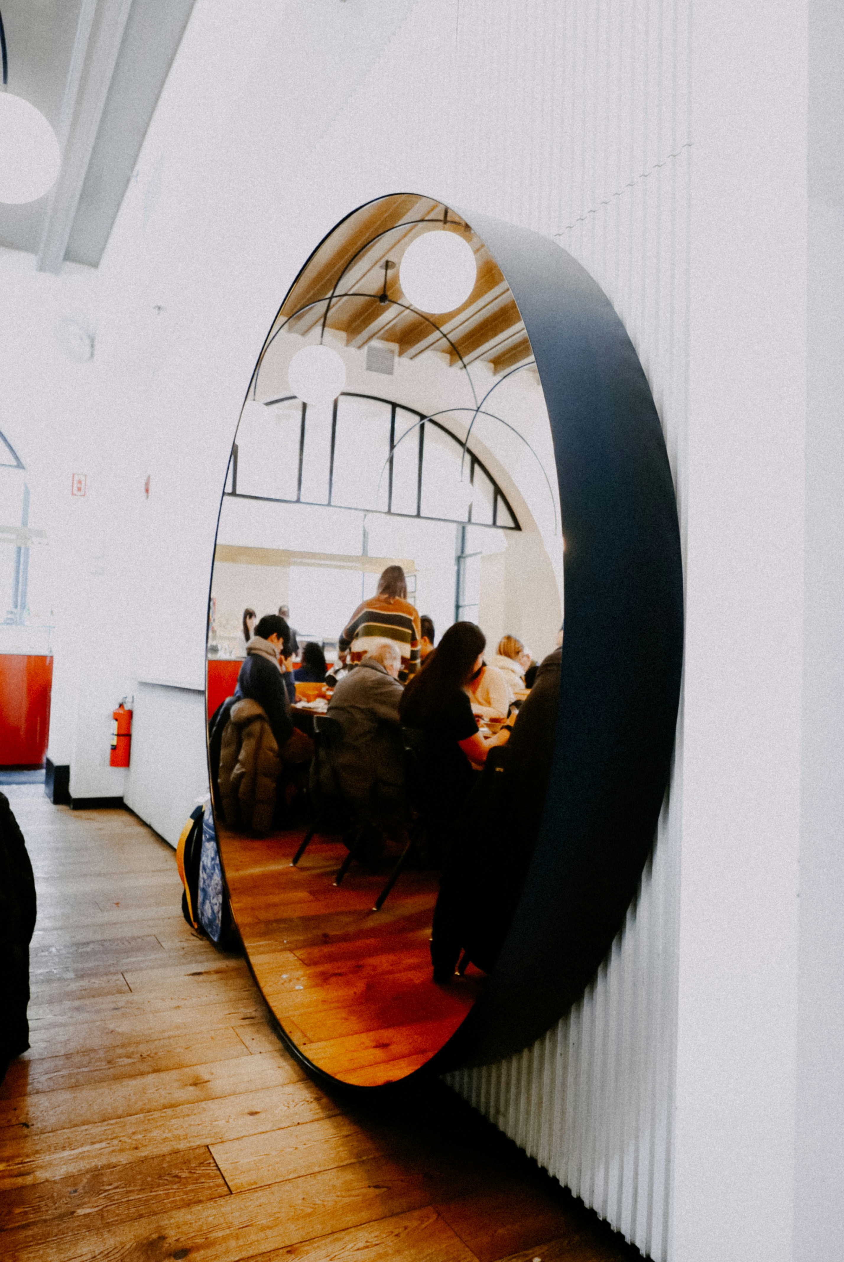 A large round mirror sitting on top of a wooden floor photo – Free ...