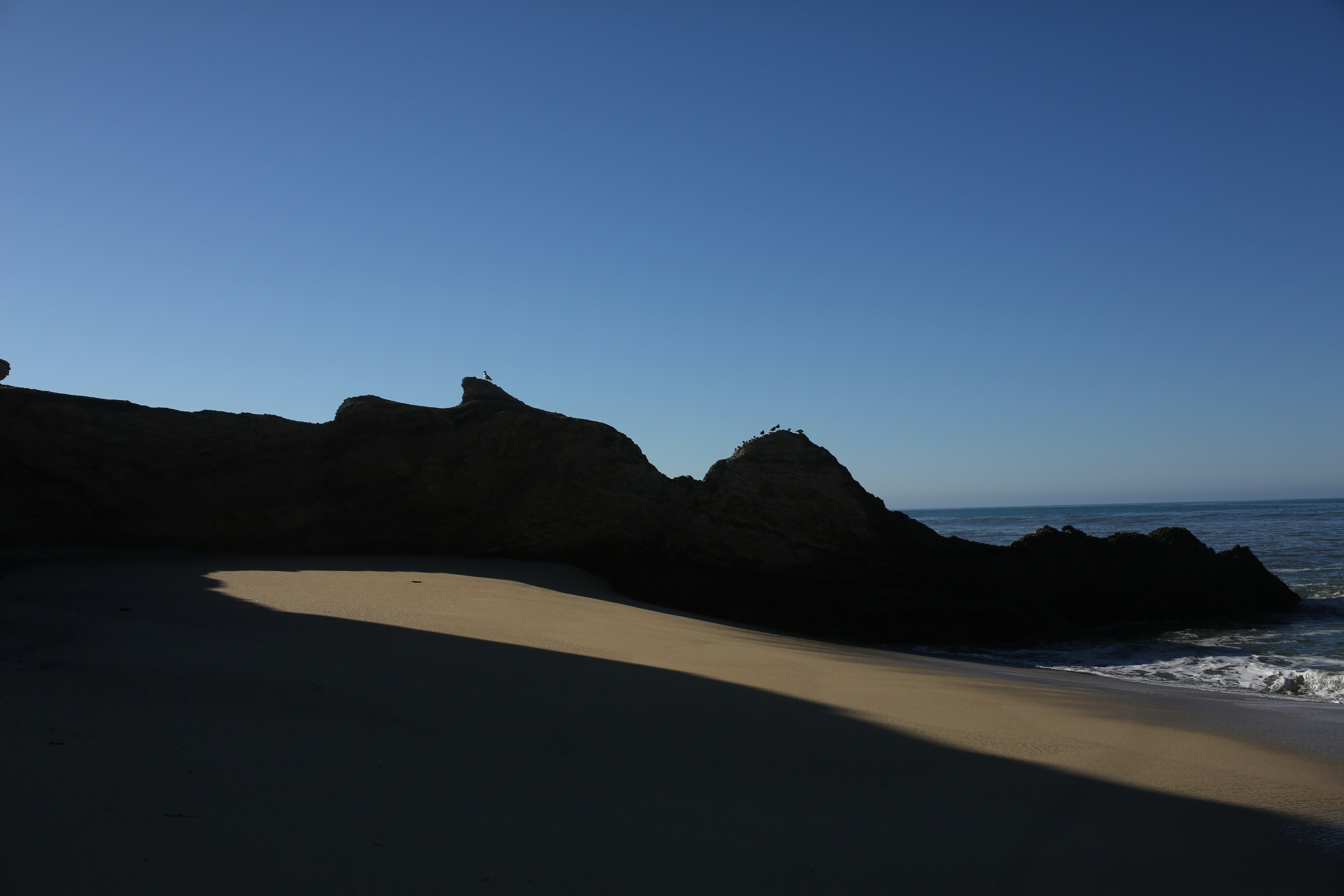 Rock Ridge and a Diagonal Slice of Light on a Quiet Beach