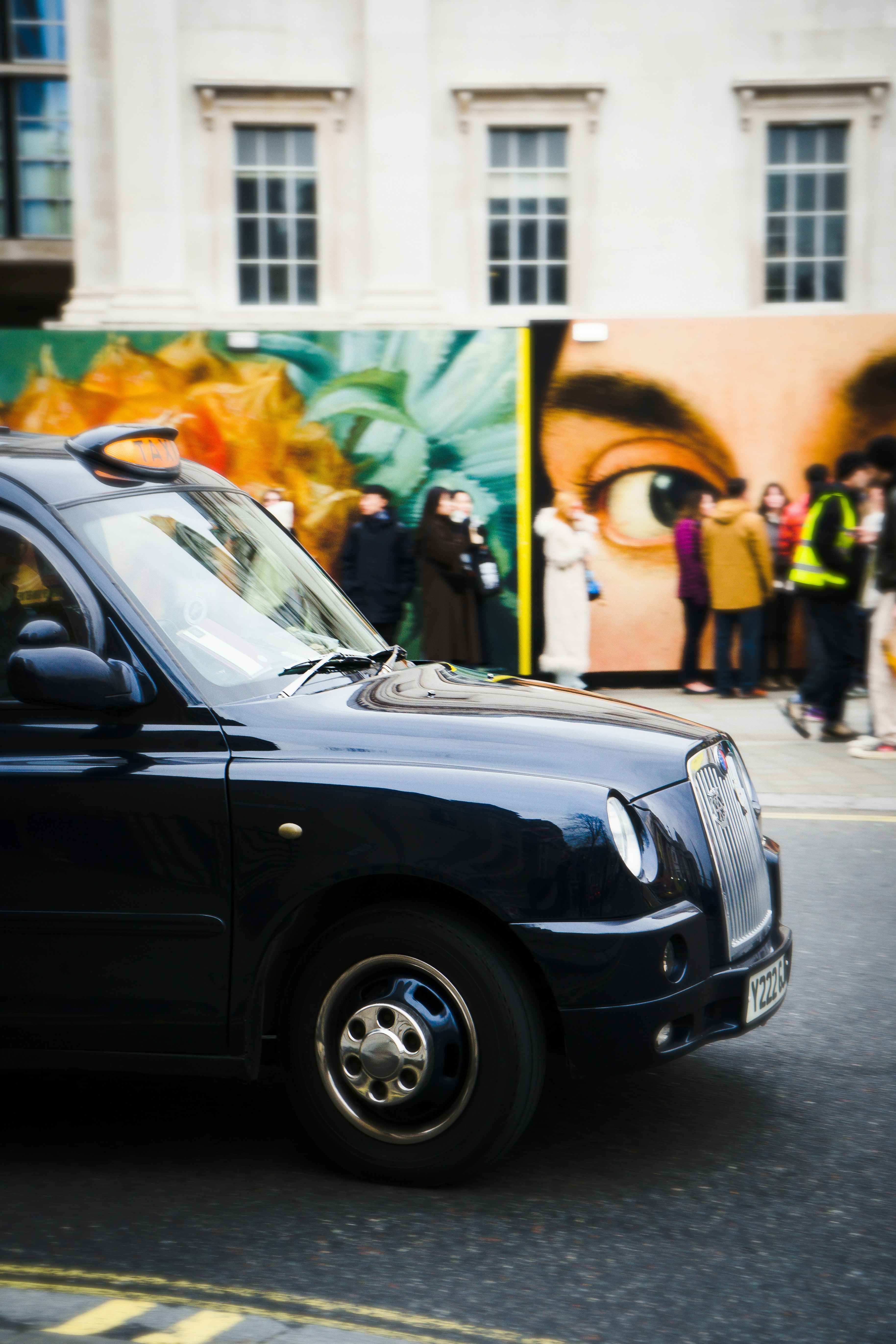 A black cab driving down a street next to tall buildings photo – Free ...