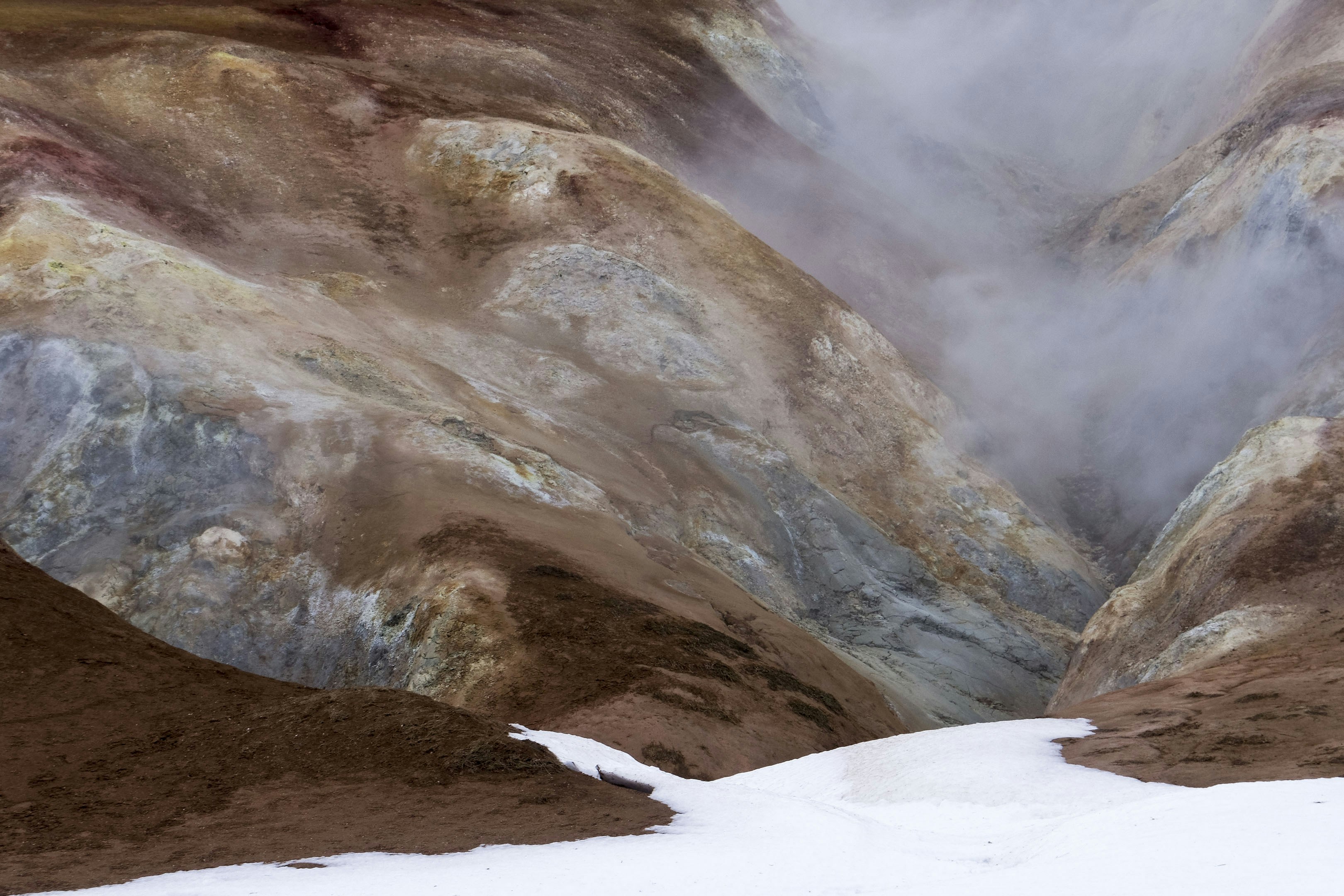 A snow covered mountain with a small patch of snow in the foreground ...