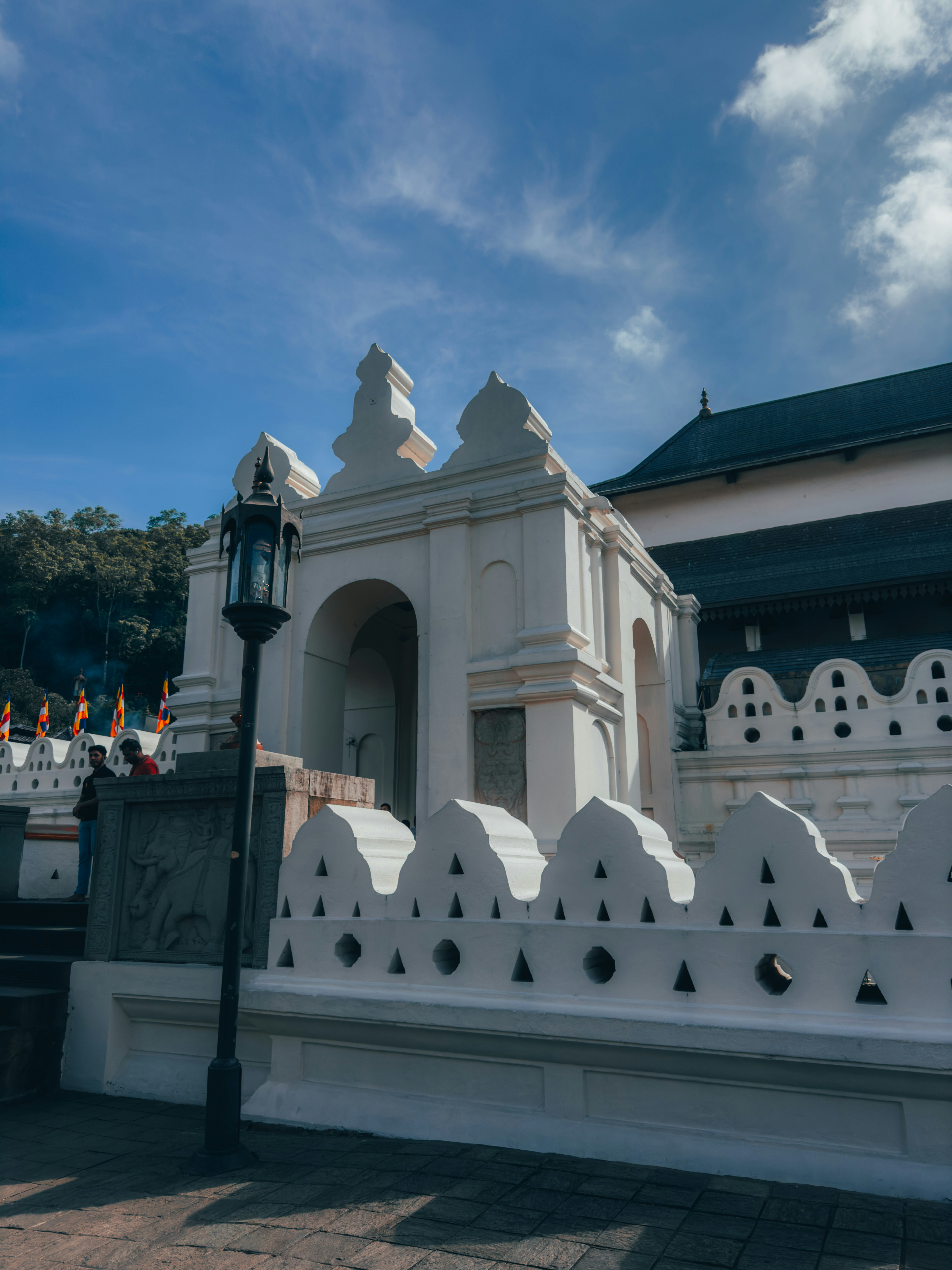 Sunlit Archway and Lantern Gate Framing a White Temple Courtyard