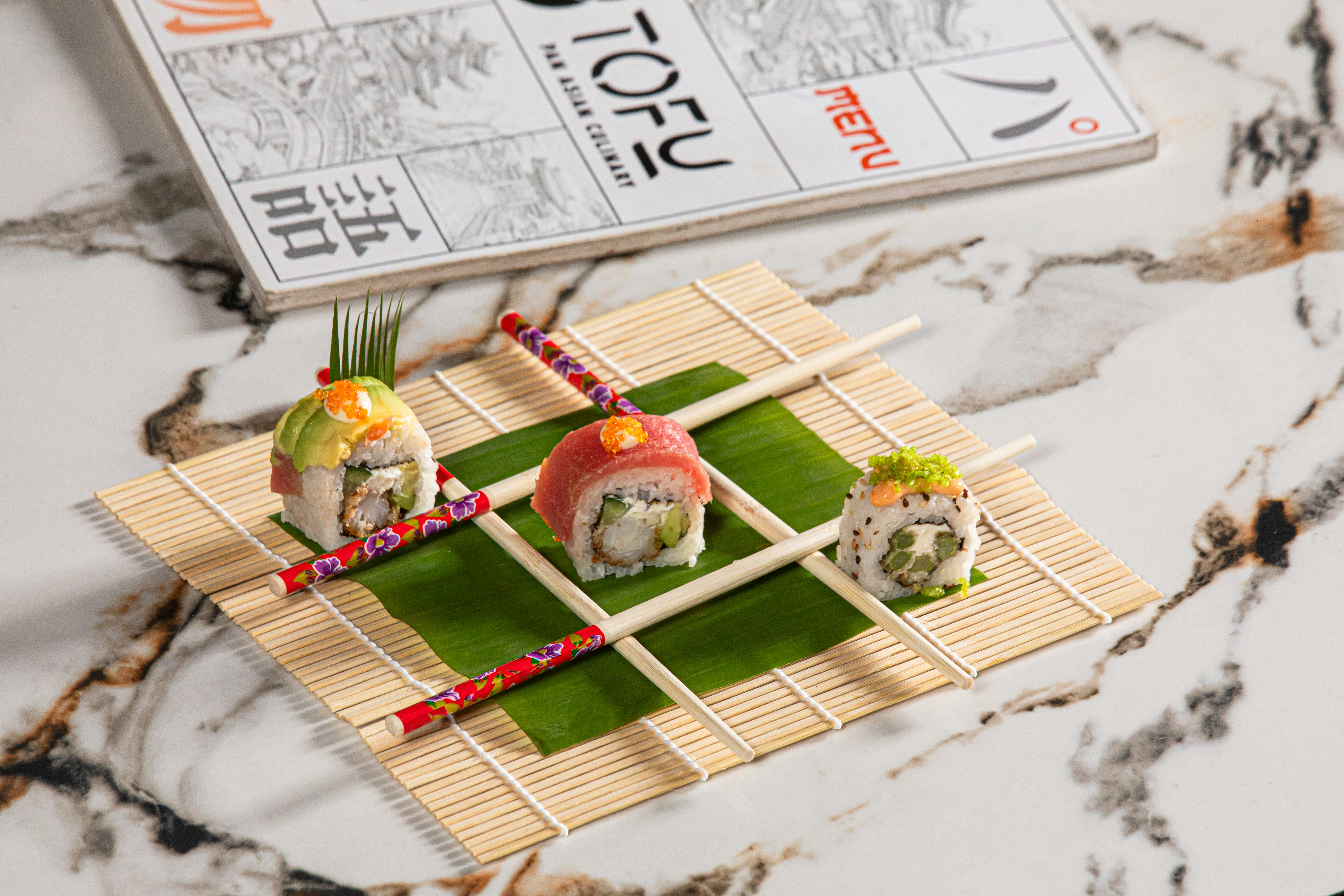 Trio of Colorful Sushi Rolls Arranged on a Bamboo Mat