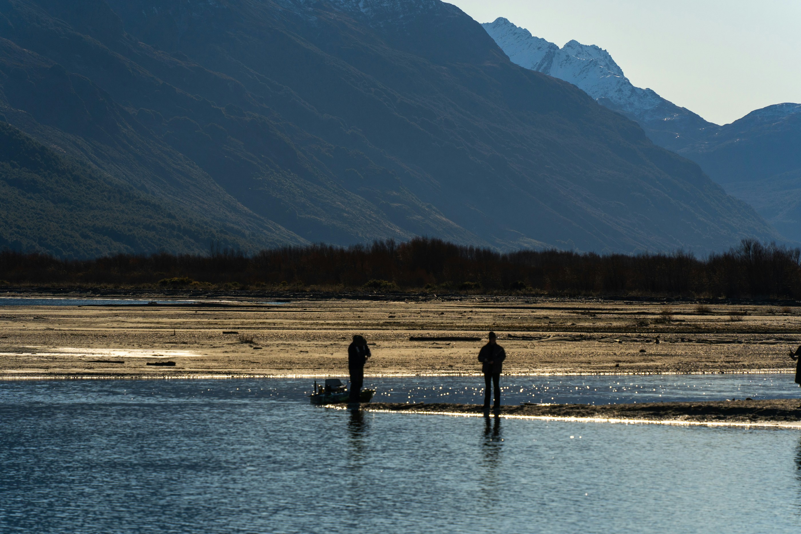 Figures at the Lake's Edge Under Silent Alpine Peaks