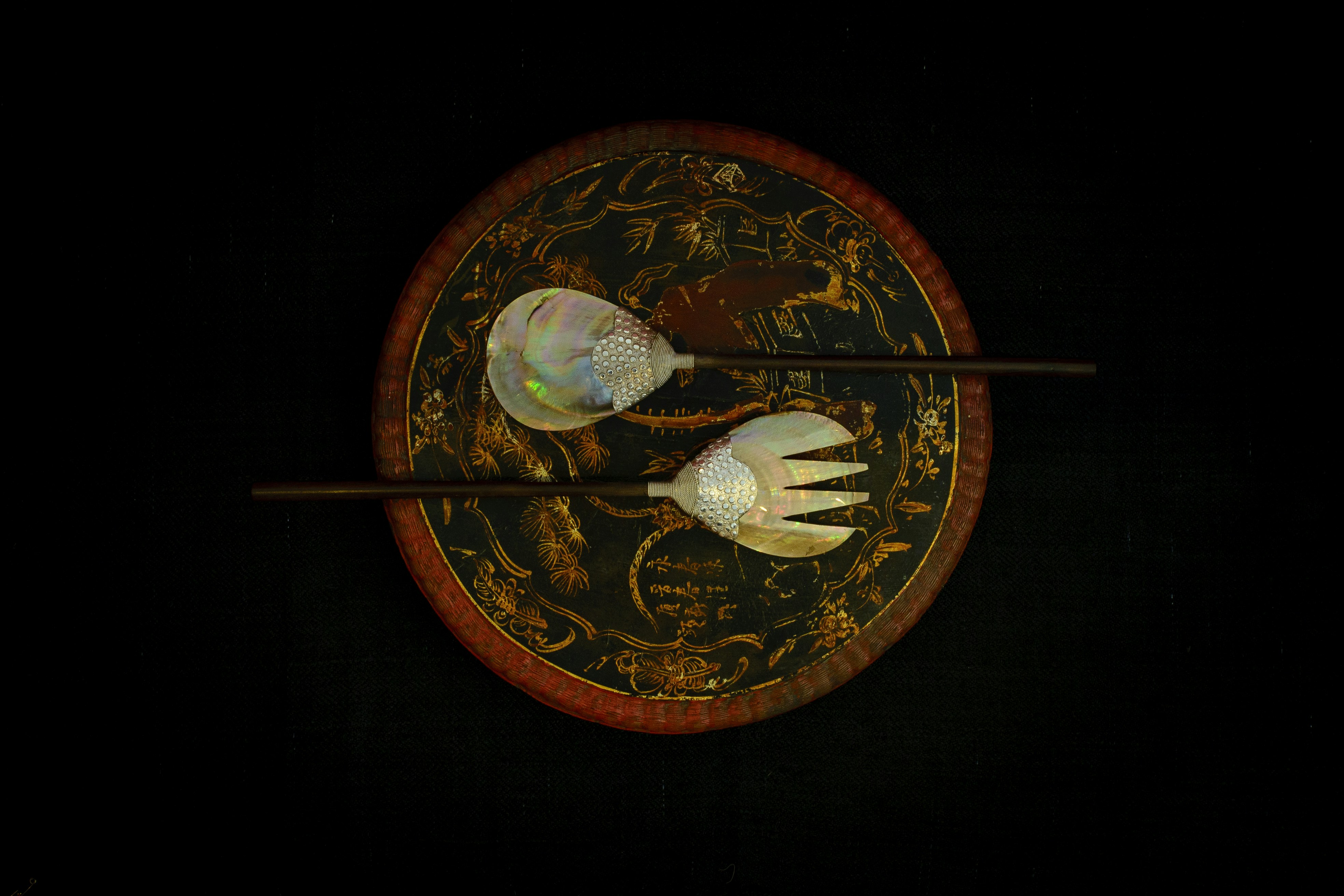 Echoes in Gold: Two White Glove Shapes Rest on an Ornate Plate