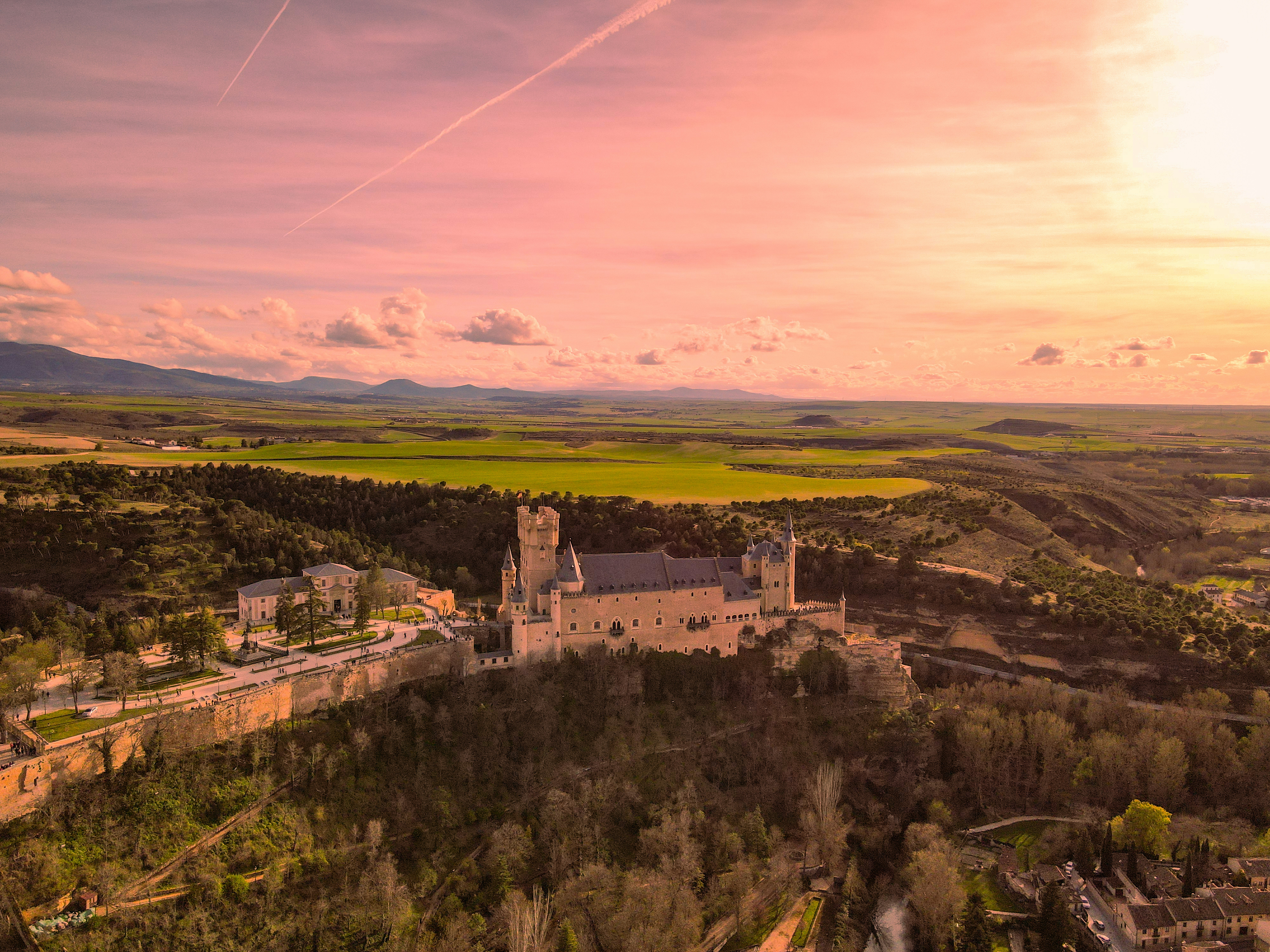 Amber Dusk Over a Hilltop Fortress: Aerial Panorama of Stone and Fields