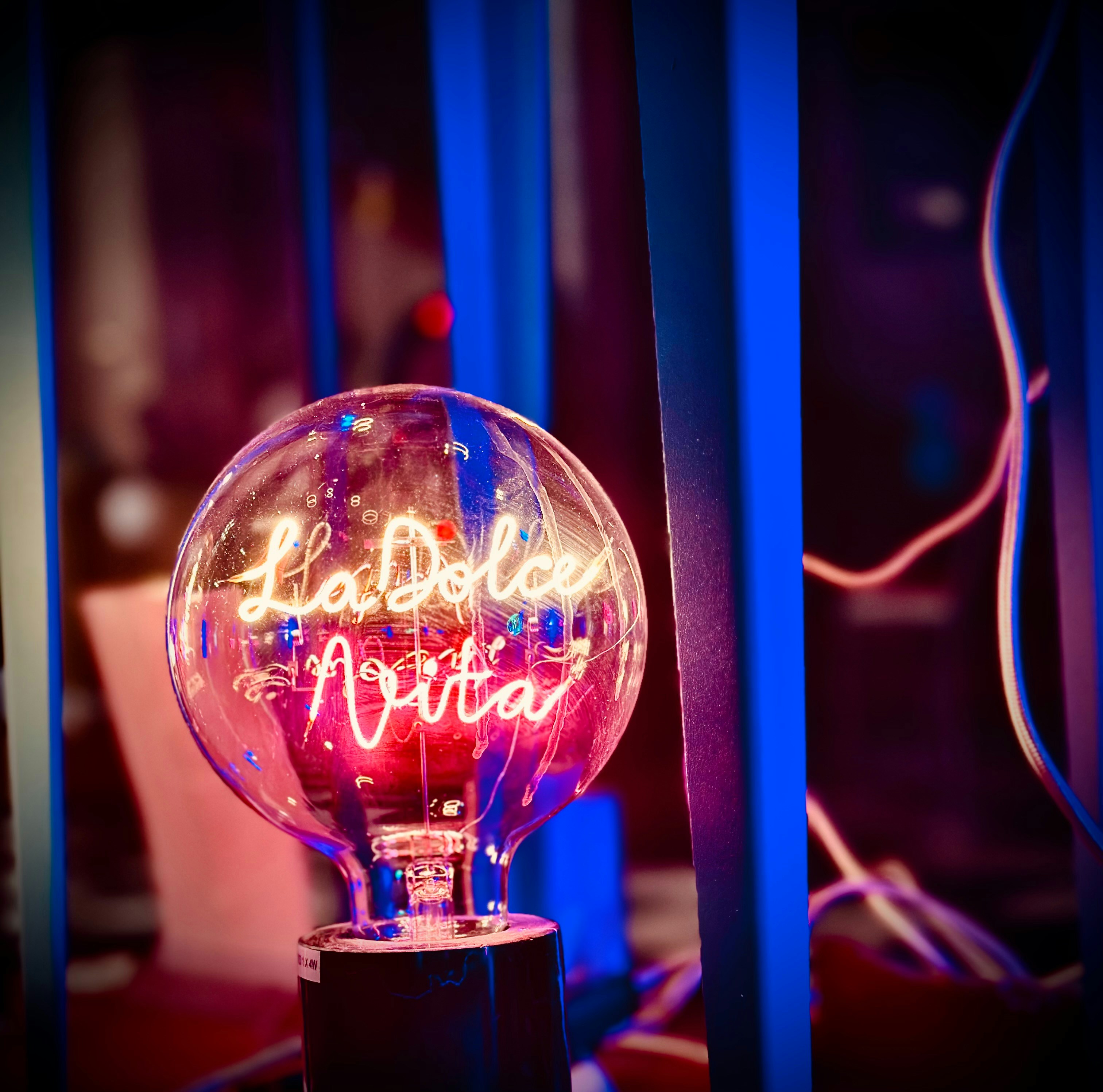 Neon Filament: A Glow-Bordered Bulb in a City of Blues