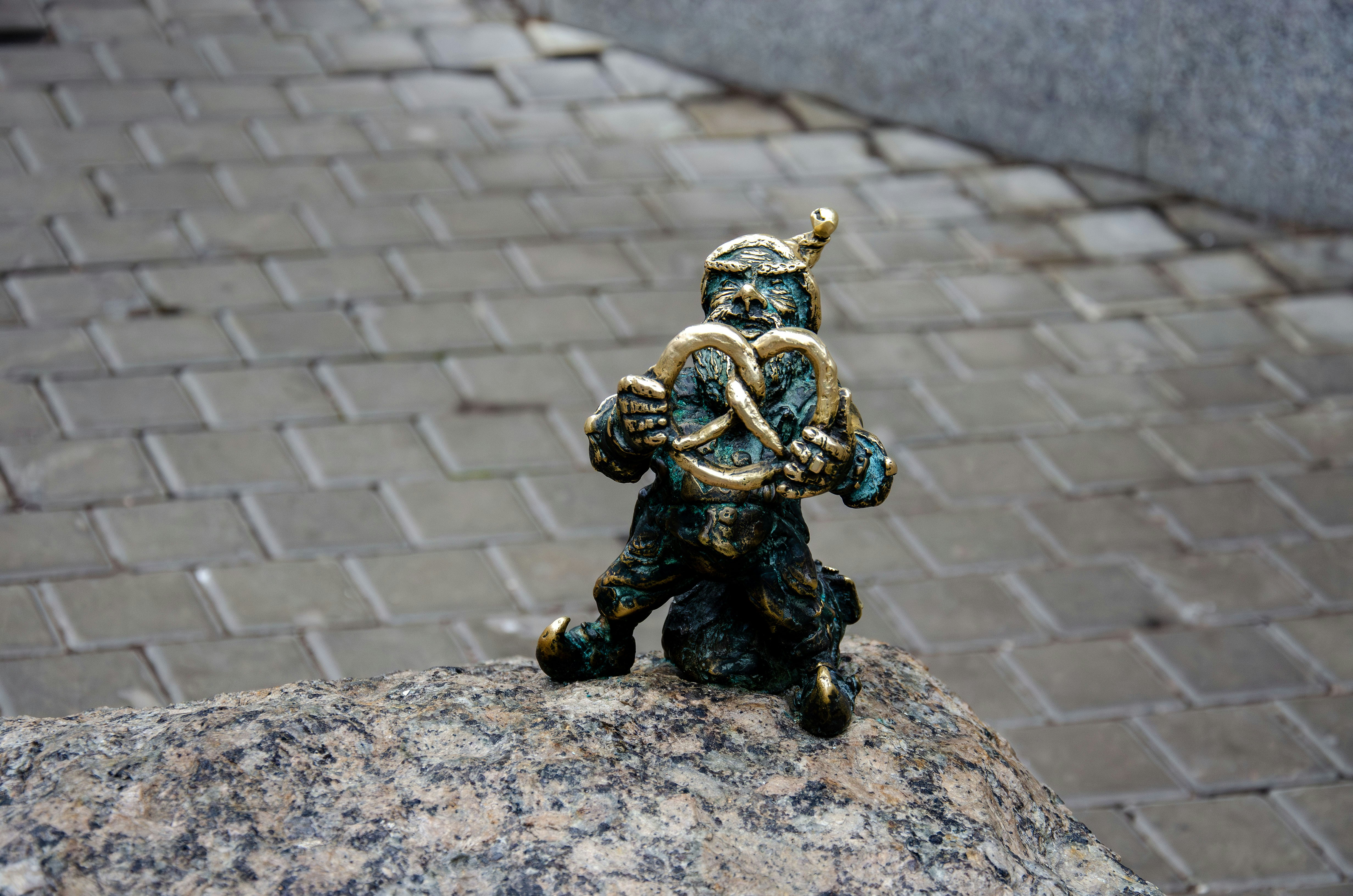 Bronze little guardian: a tiny statue perched on stone