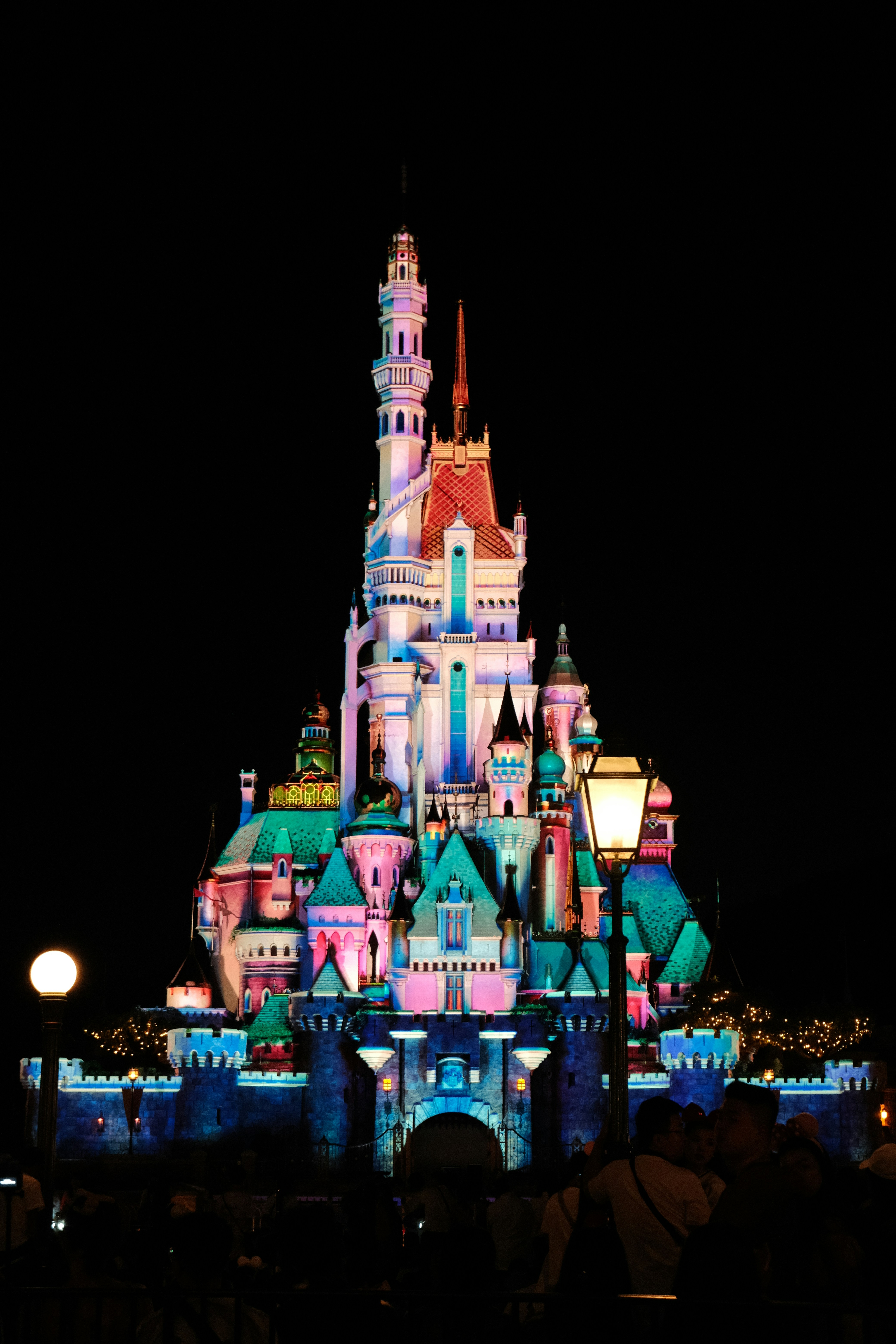 A castle lit up at night with a lot of lights photo – Free Building ...