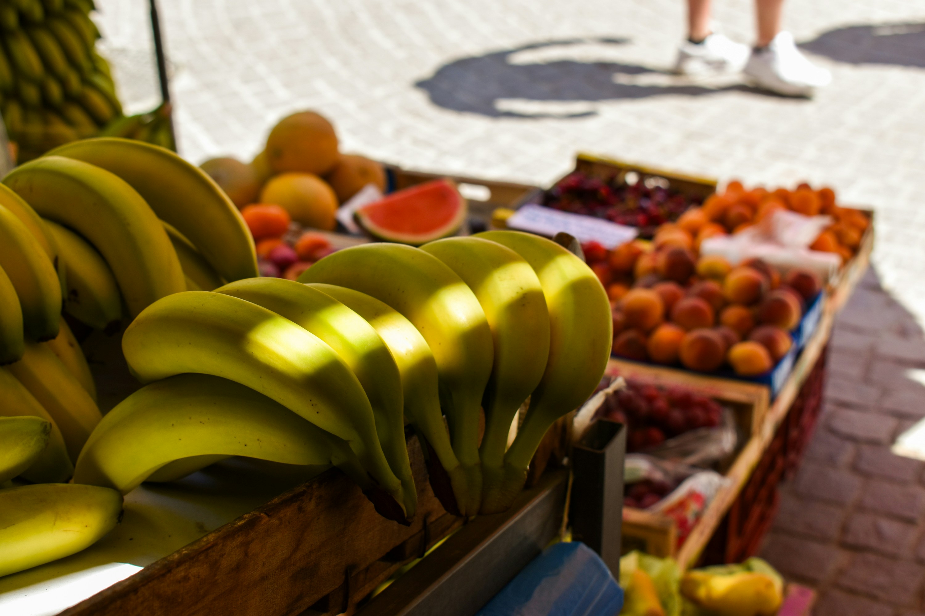 A streak of sunlight hits bananas at a fruit and vegetable market in Crete.