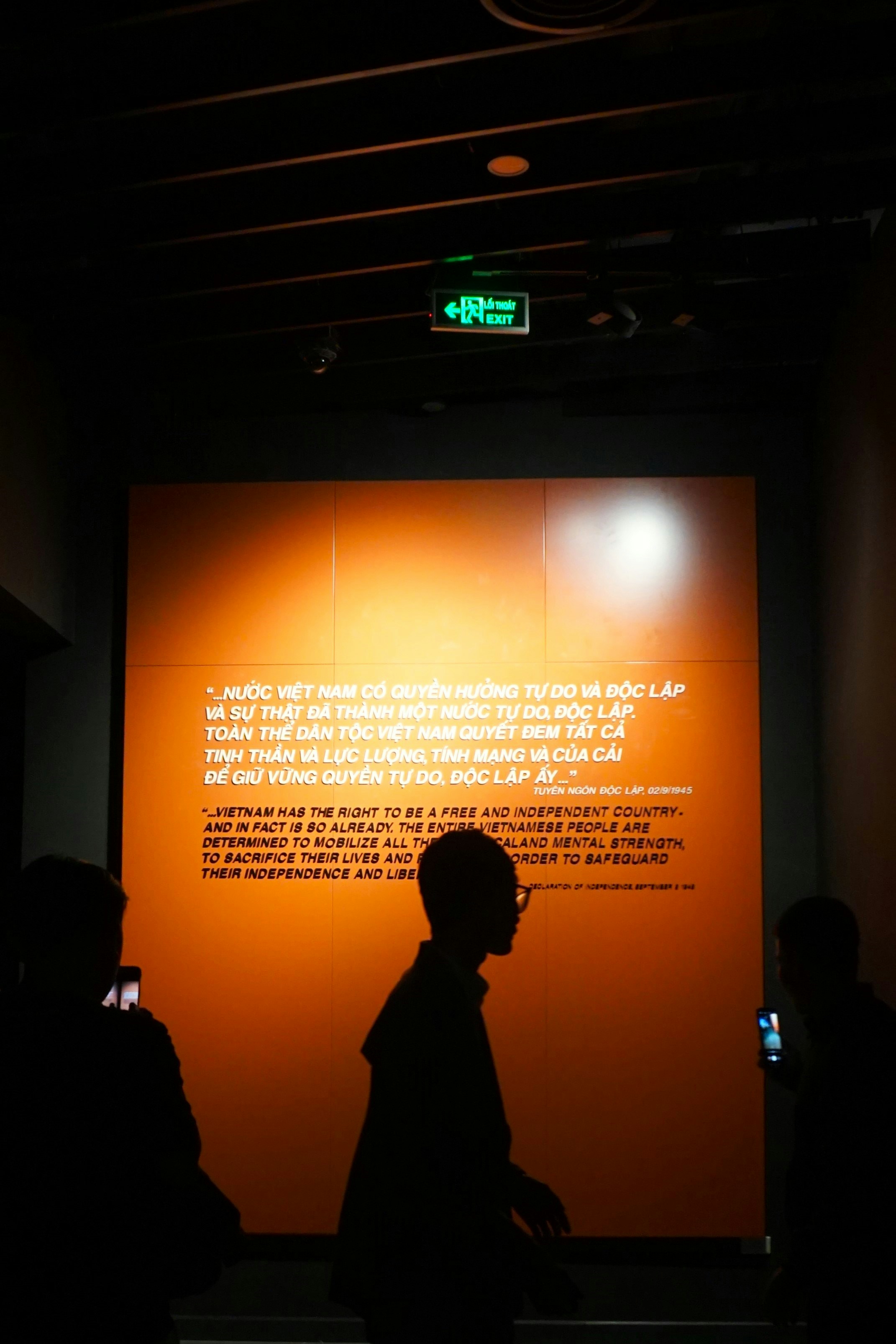 Quiet Fire: The Orange Wall of Words in a Dim Gallery