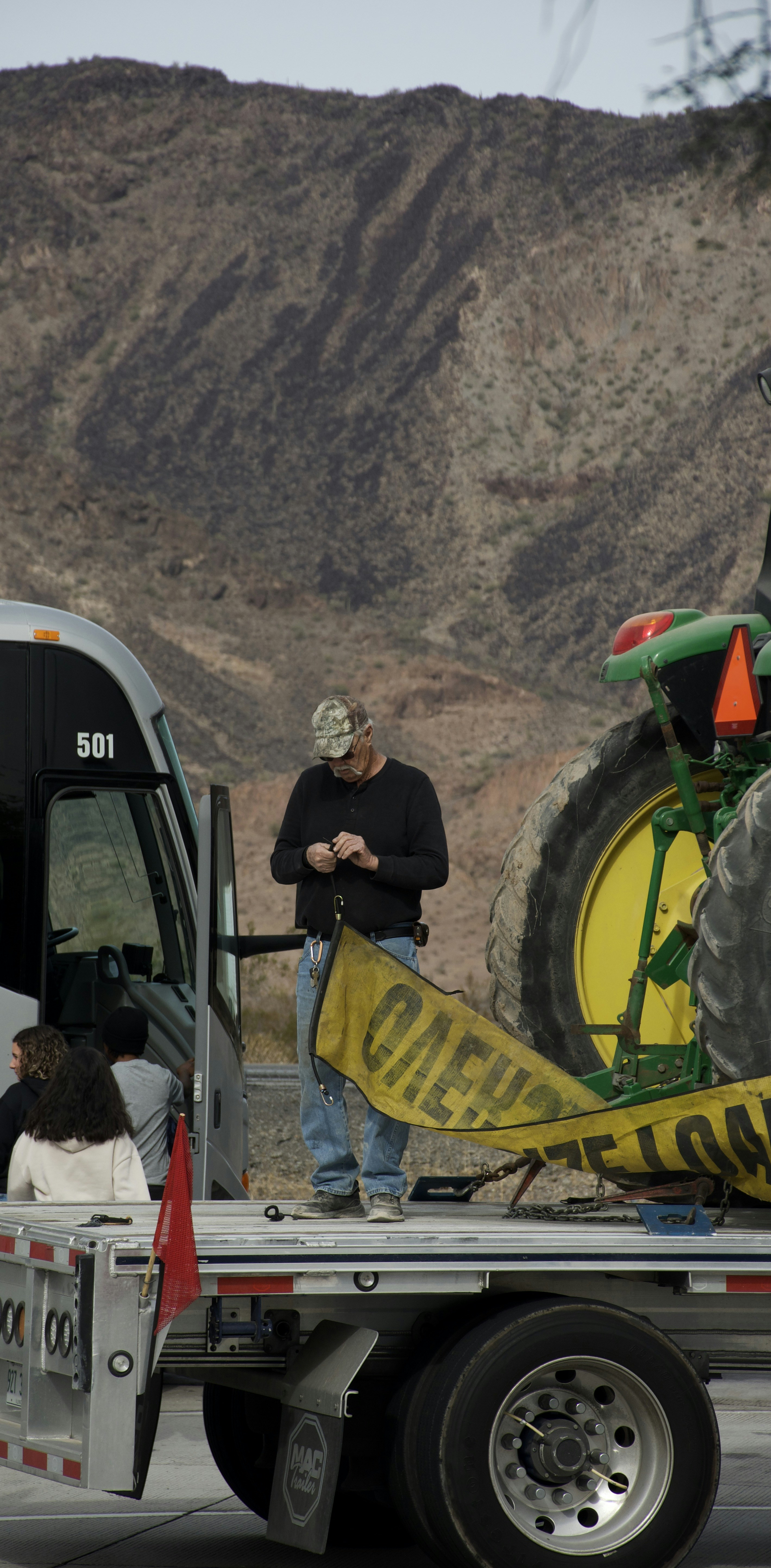 A tractor trailer with a tractor on the back of it photo – Free Bus ...