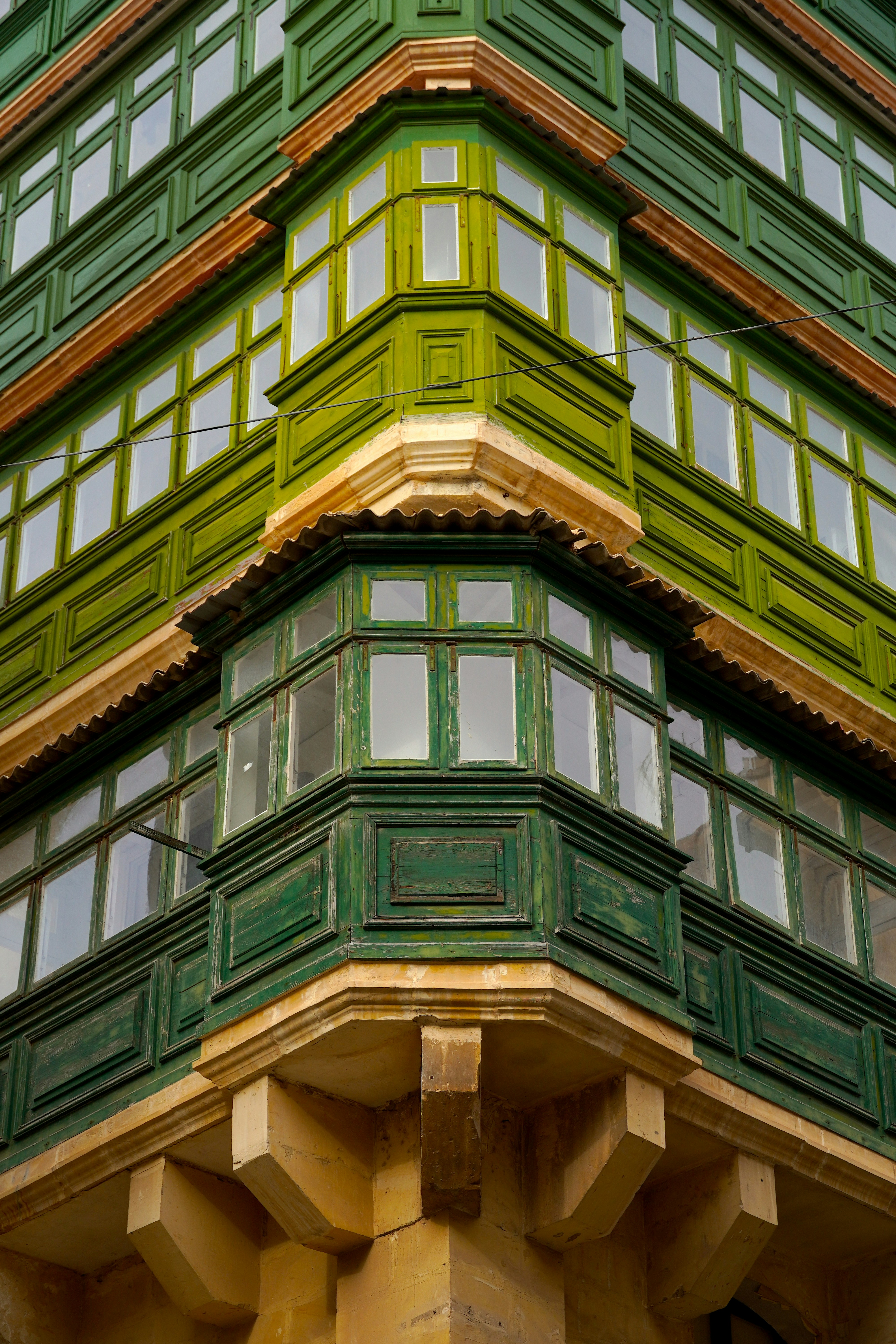 Verdant Corner: Layered Green Facade with Window Bays
