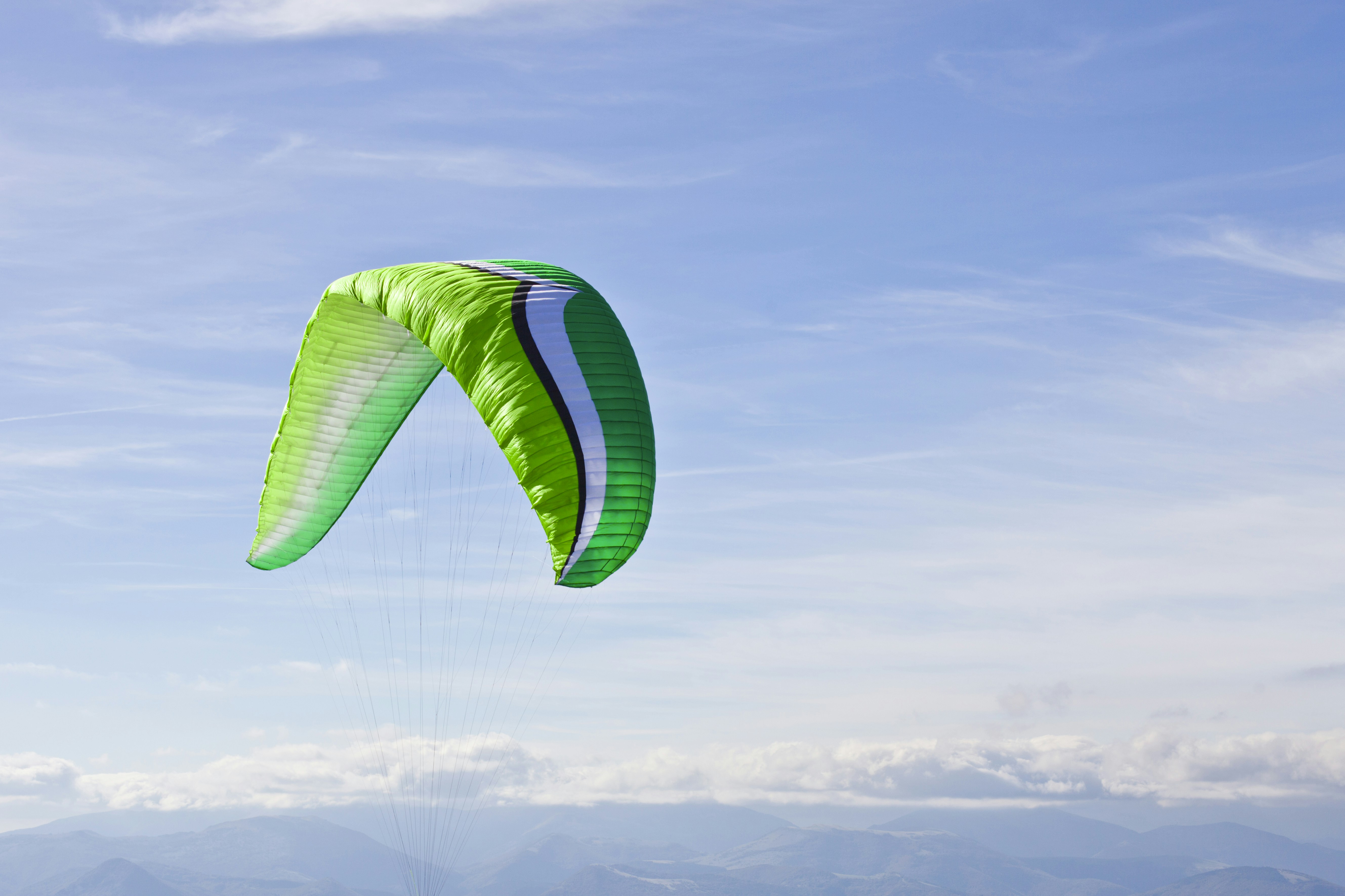 Emerald Wing Over Alpine Blue: Paraglider's Quiet Glide