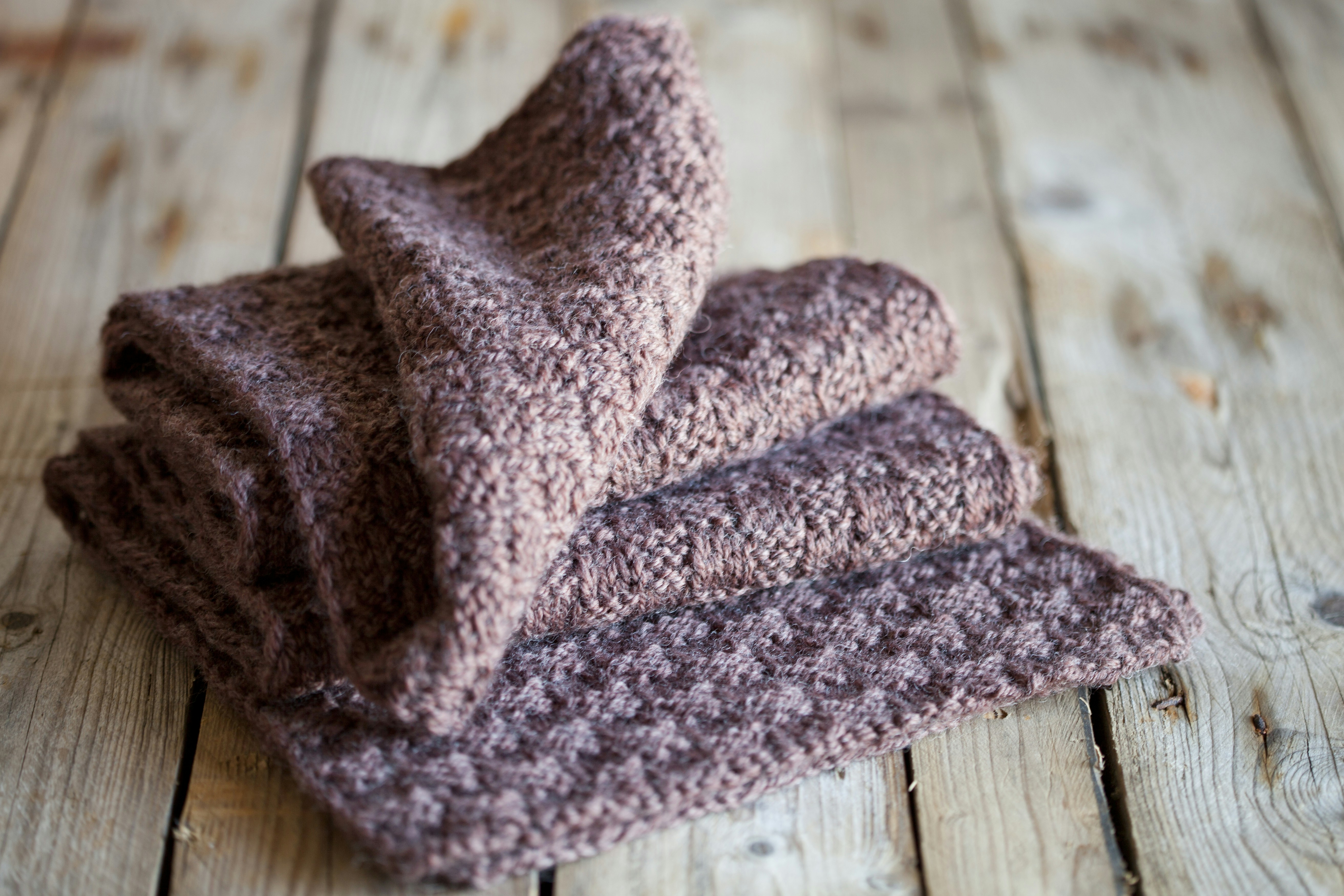 Threaded Warmth: Close-Up of Brown Knit on Weathered Wood