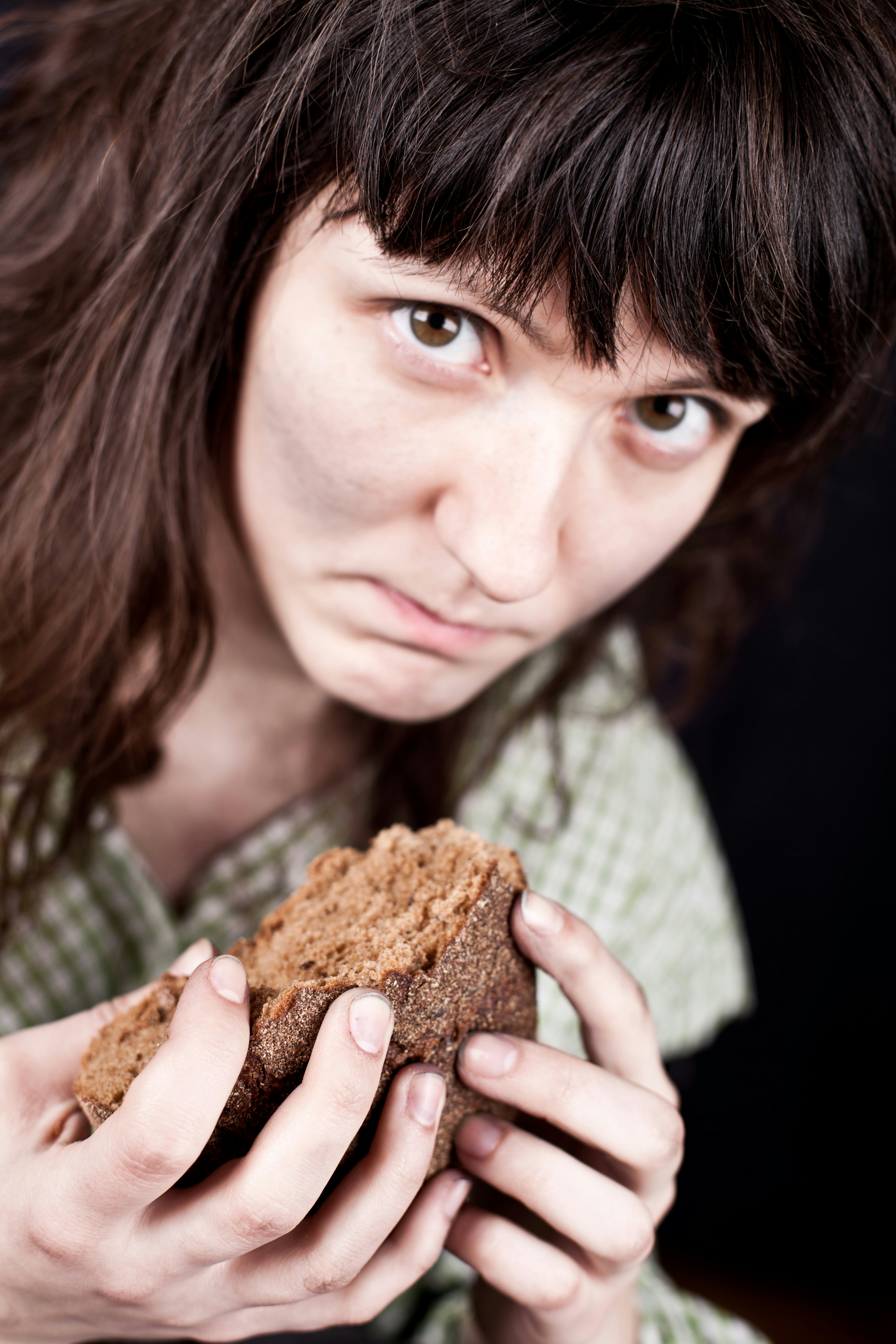 Close-up of a pensive expression while holding a loaf slice