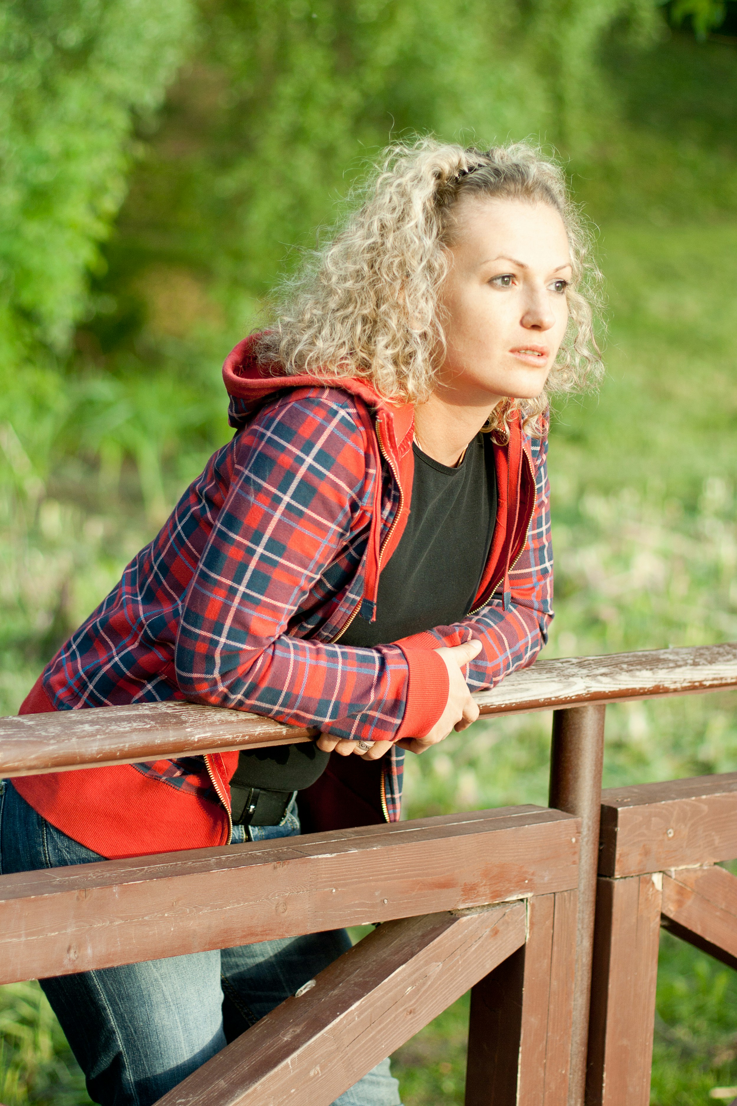 A woman leaning on a wooden bench in a park photo – Free Portrait Image ...