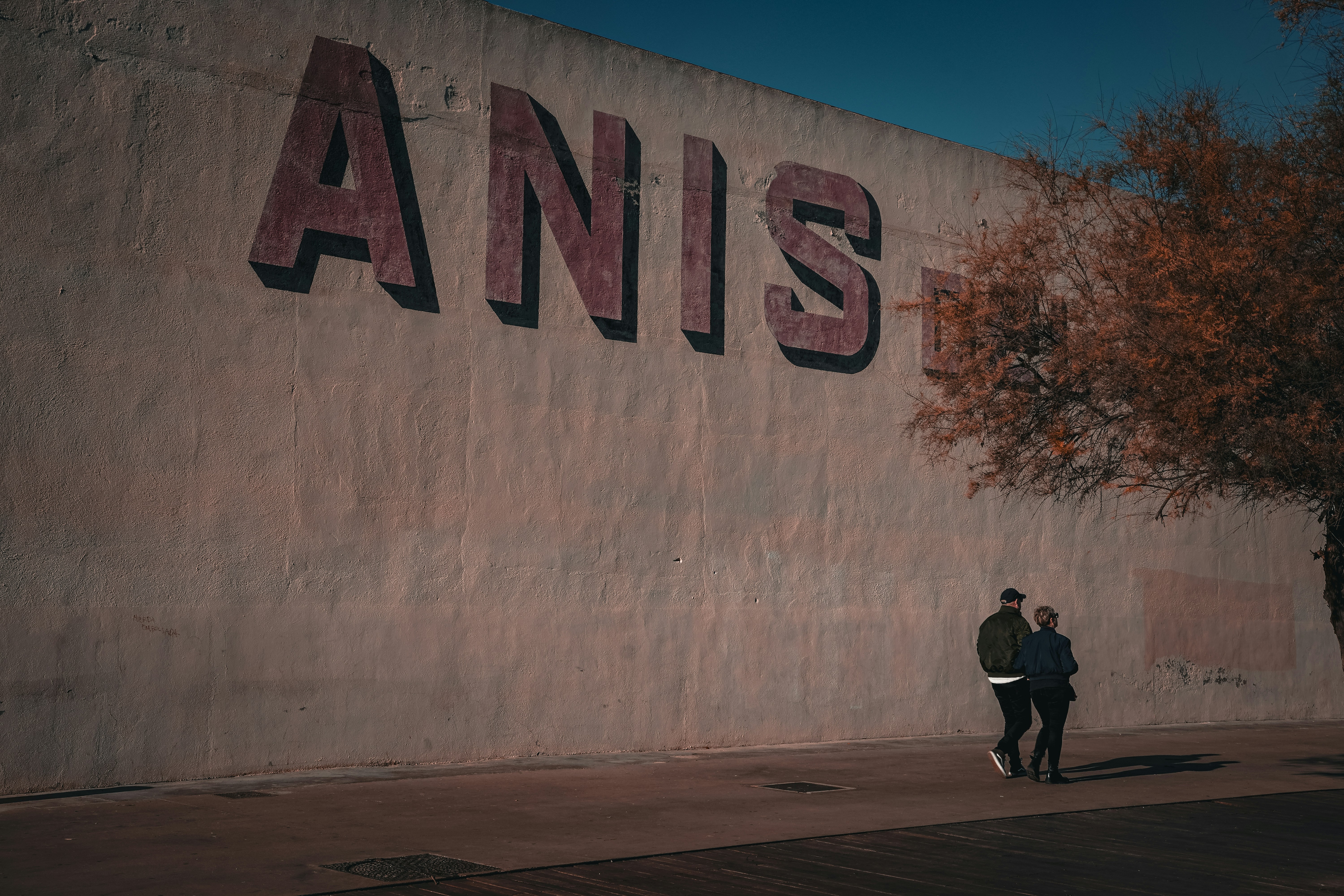 Dusk Stroll Along a Weathered Wall with Faded Signage