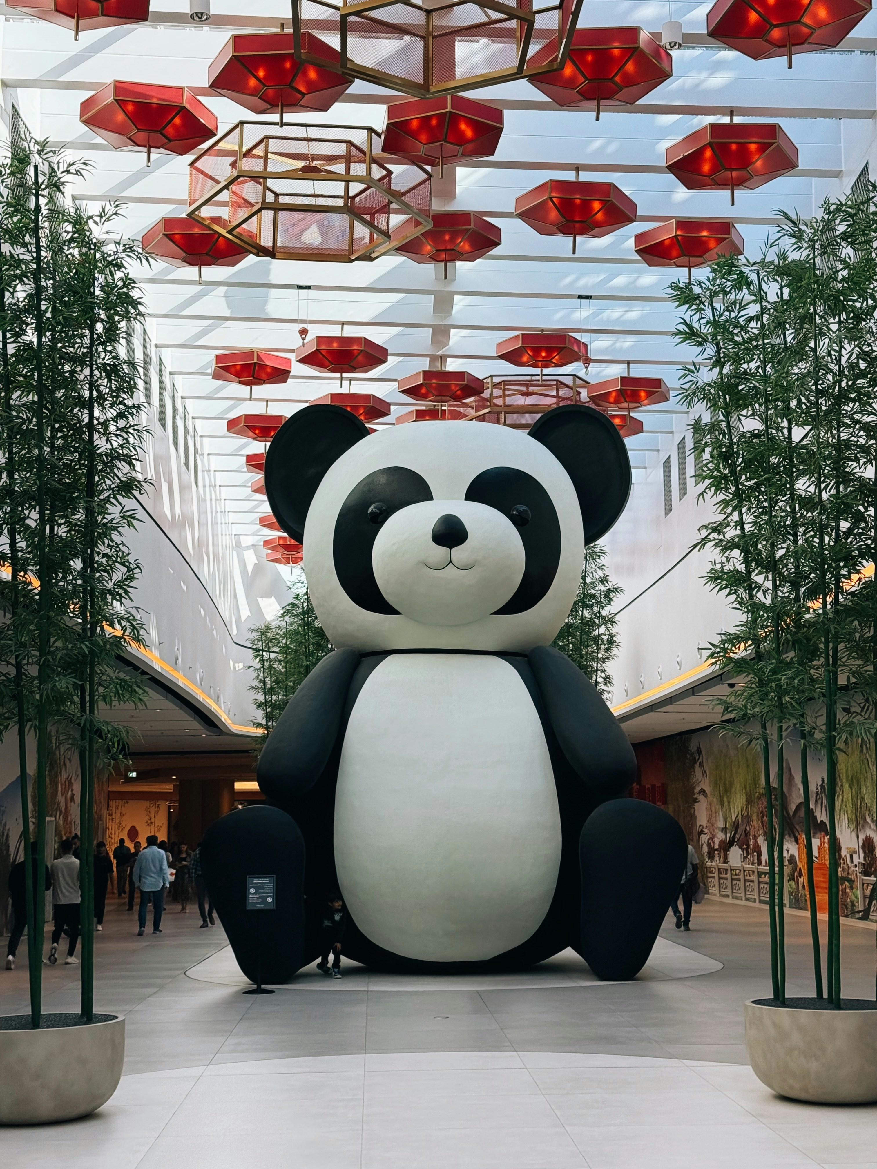 Giant Panda in a Sunlit Mall Atrium Beneath a Sky of Red Lanterns