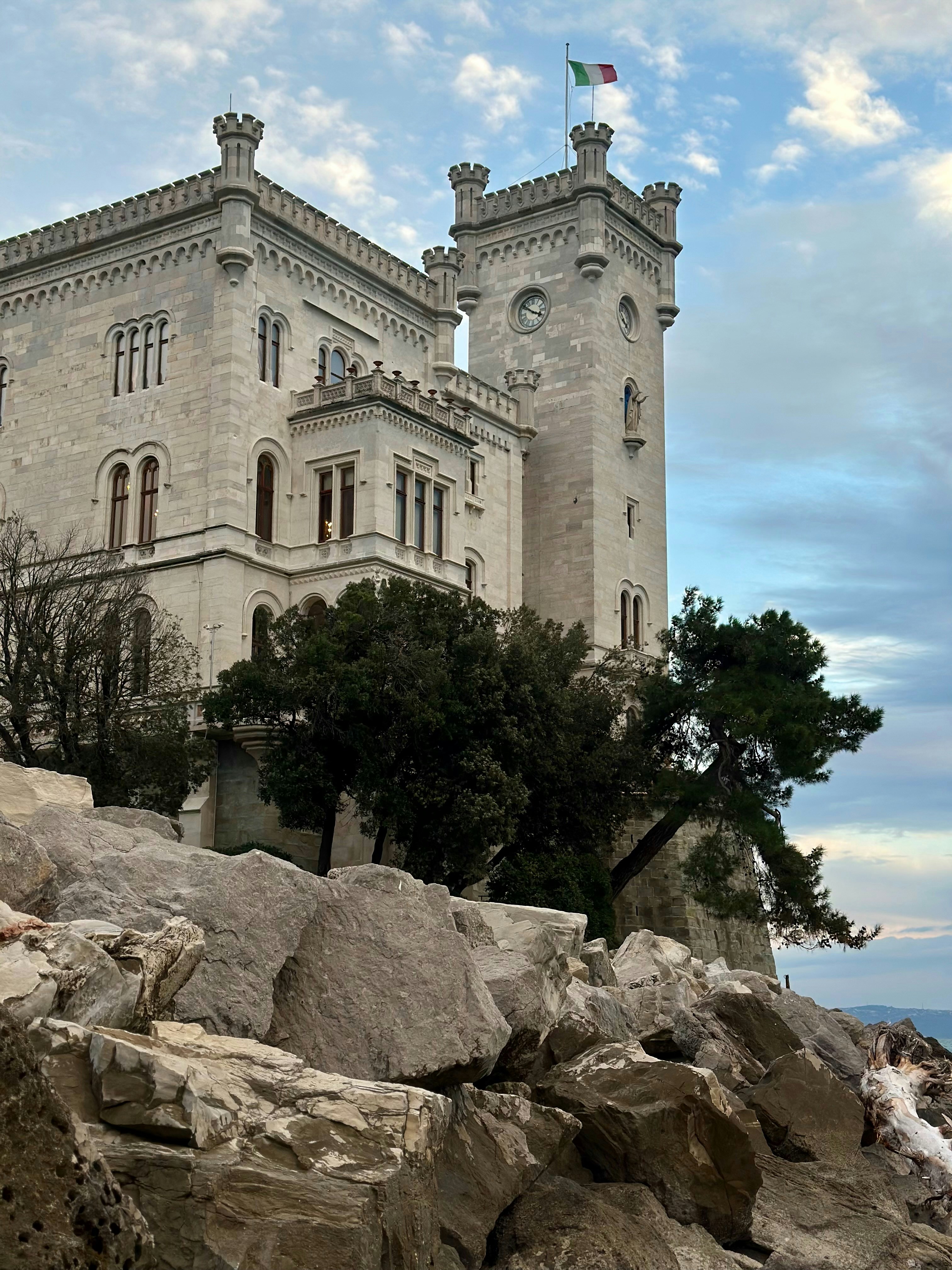 Seaside Bastion: Limestone Castle Clinging to Jagged Rocks Under a Wind-Swept Sky