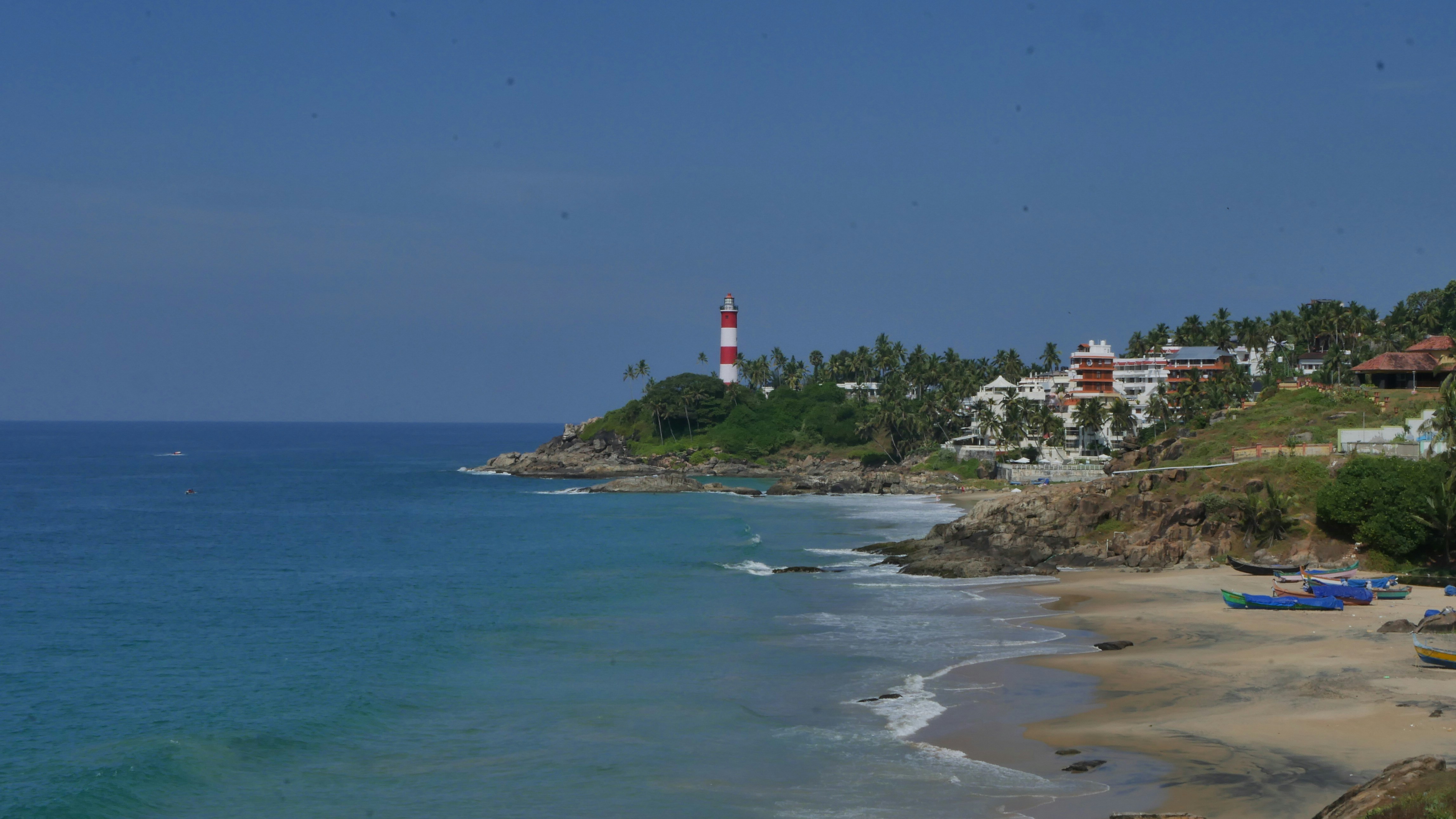 A view of a beach with a lighthouse in the distance photo – Free Nature ...