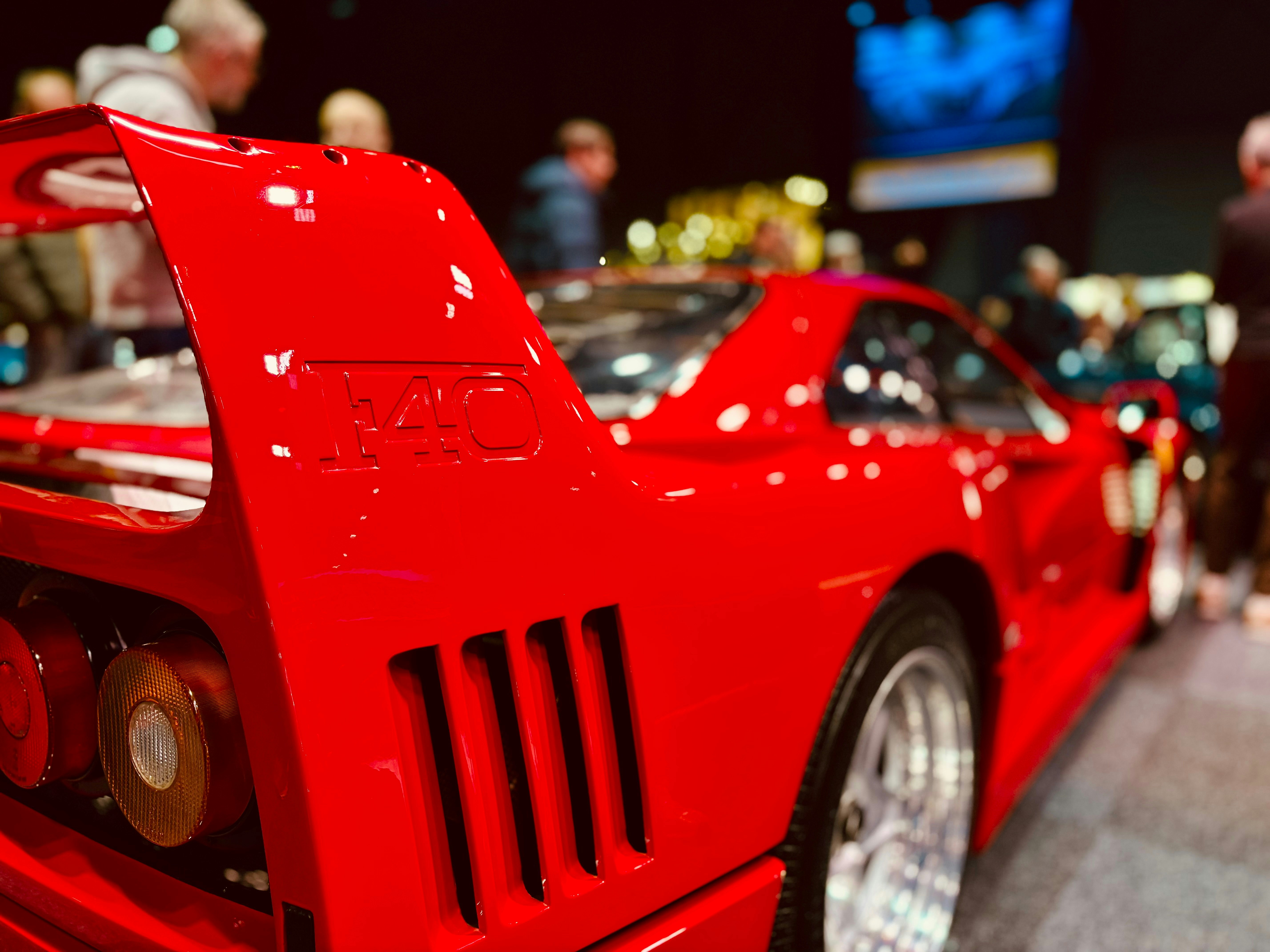 A red sports car is on display at a car show photo – Free Mecc Image on ...