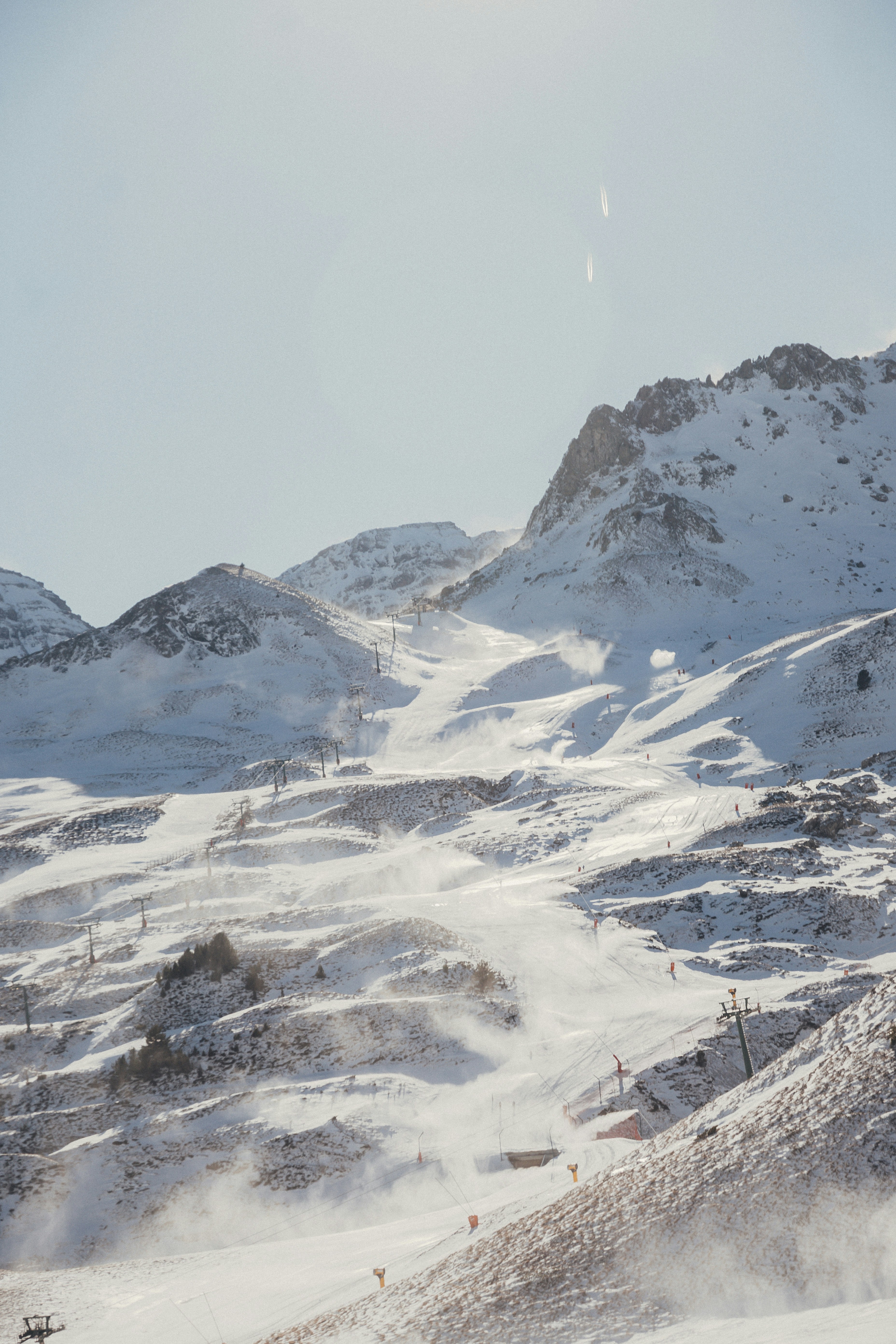 A man riding a snowboard down the side of a snow covered slope photo ...