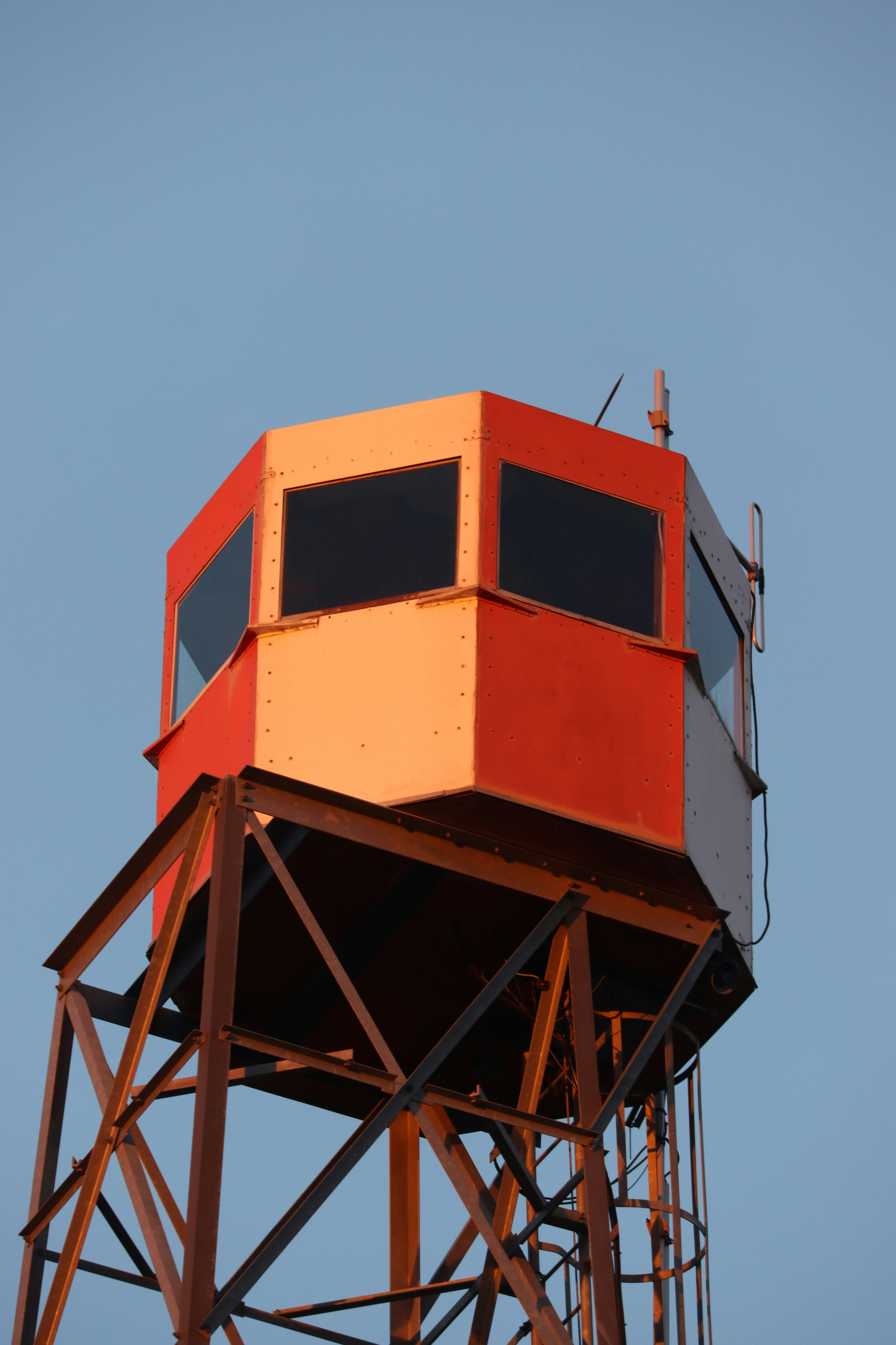 A red and orange tower against a blue sky photo – Free Tower Image on ...
