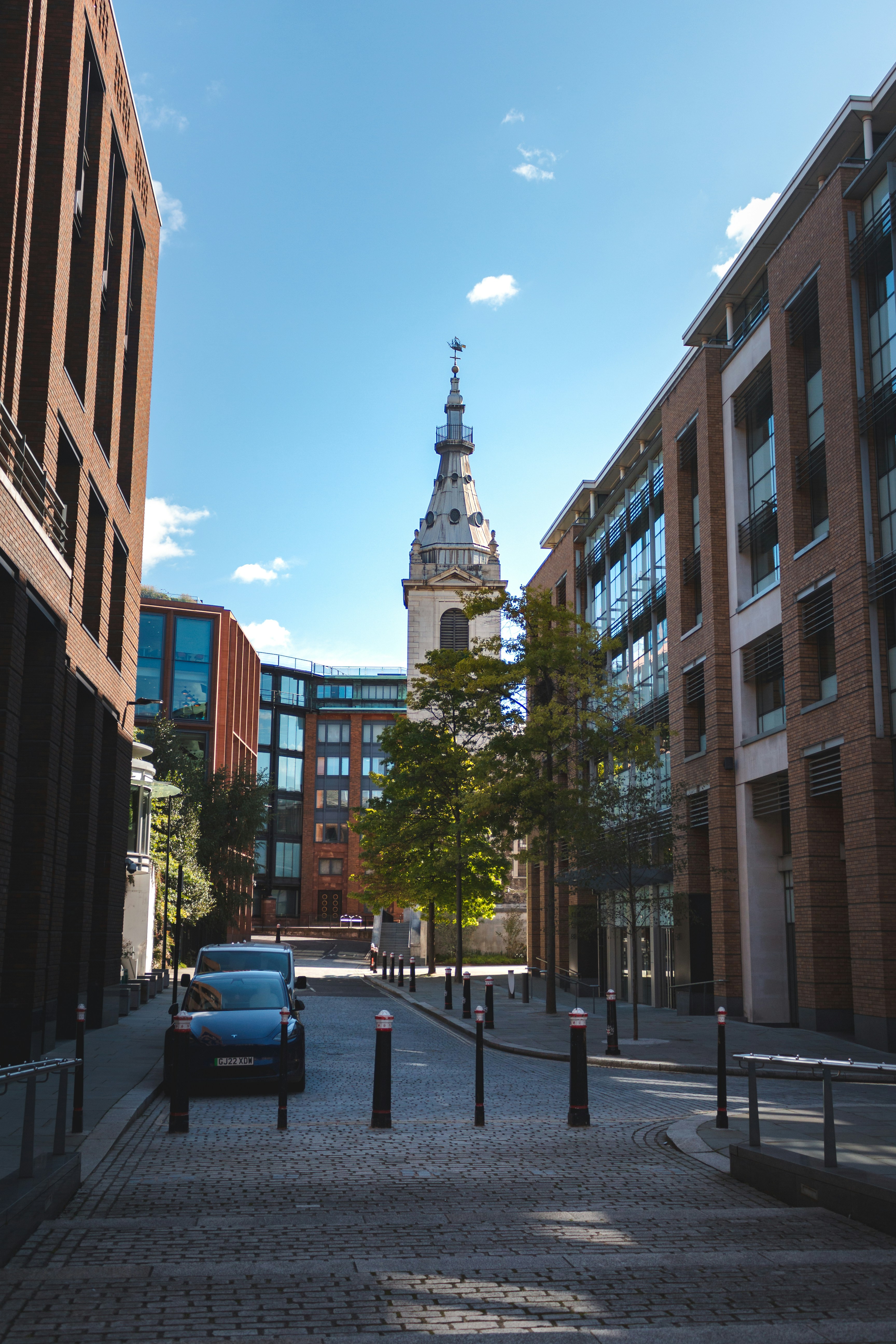 Spire in the Street: Clocktower Framed by Brick and Glass