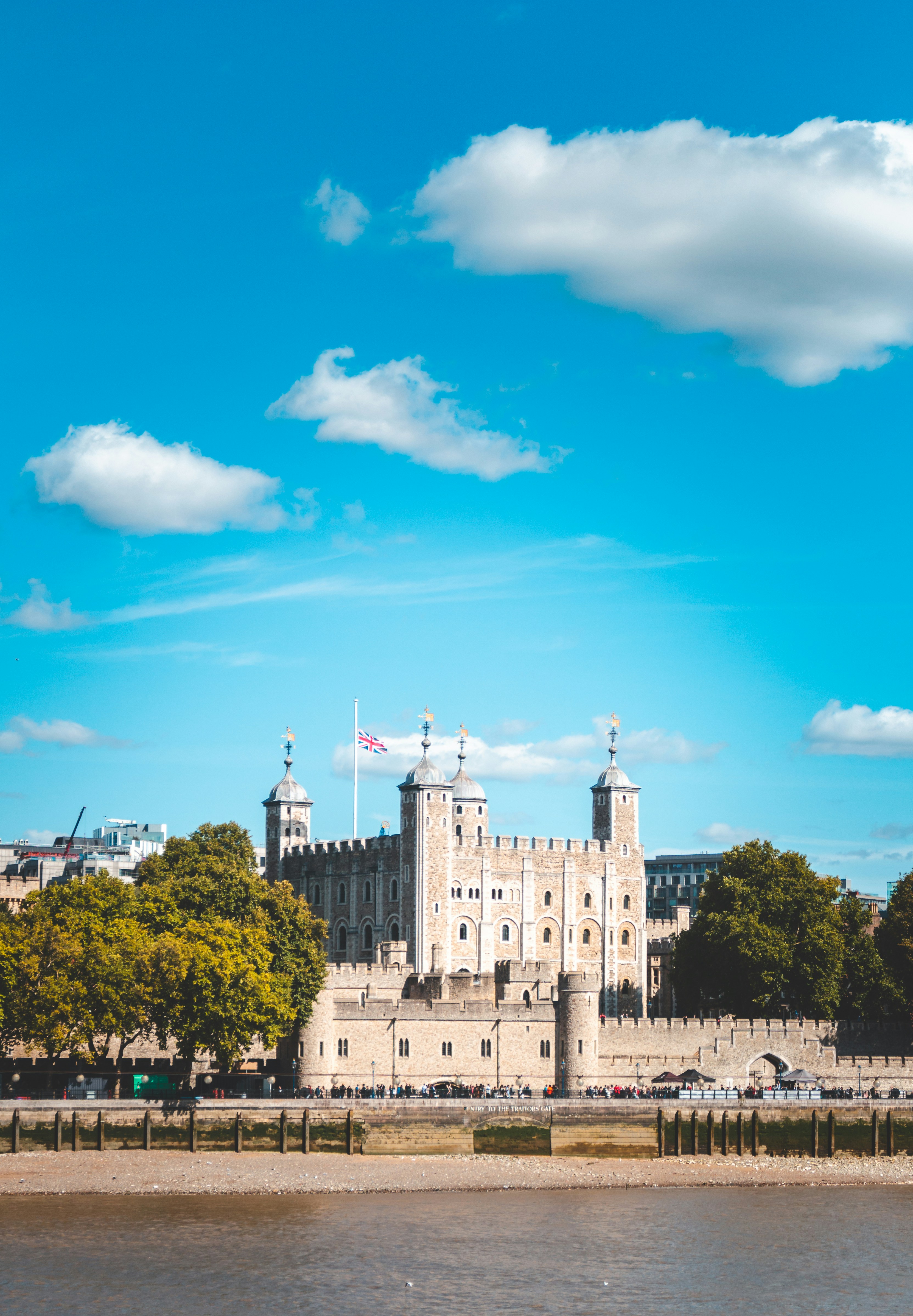 A large white castle sitting on the side of a river photo – Free ...