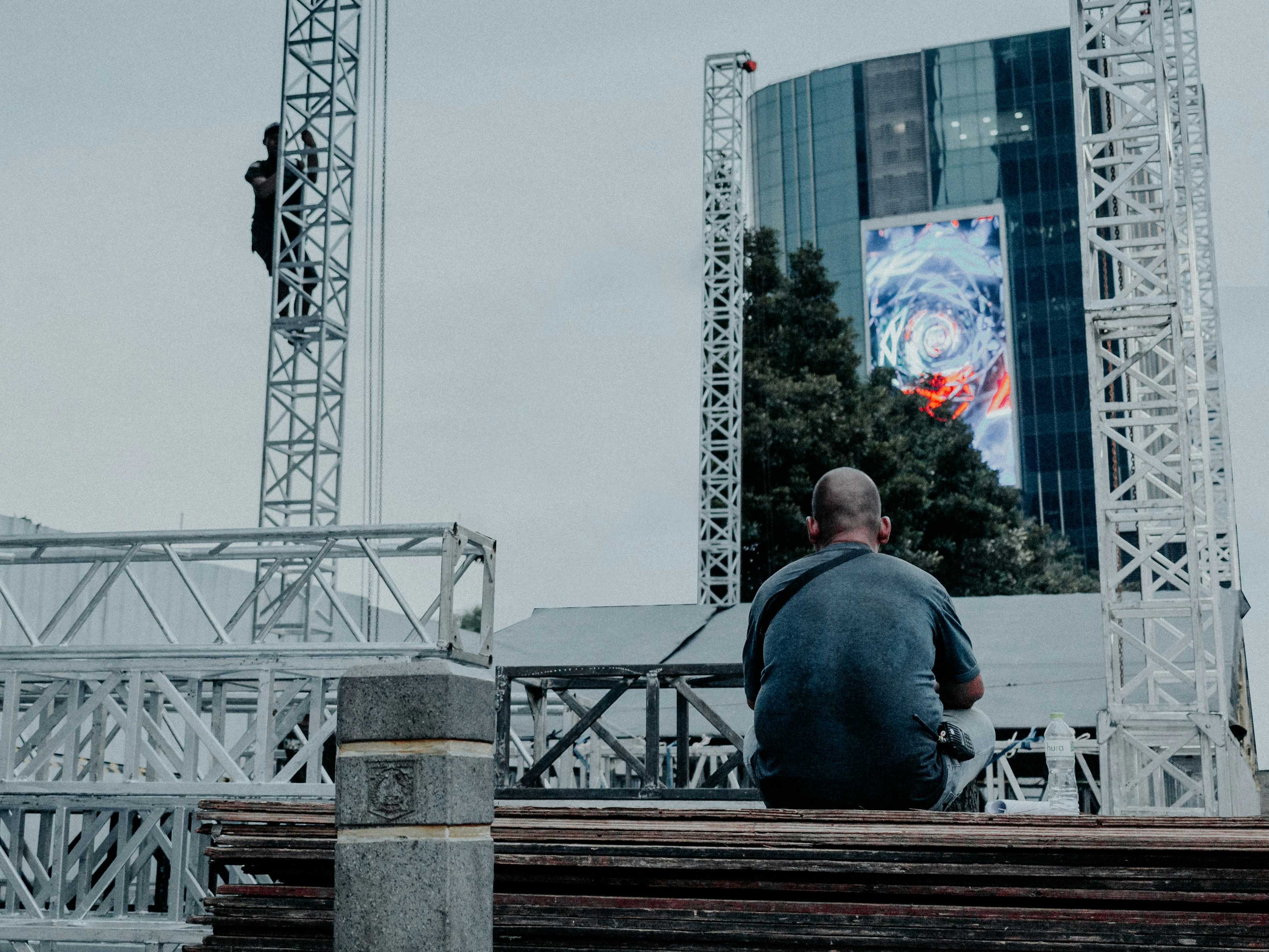 Lone Crewman on a Steel Scaffold Overlooking a Festival Stage