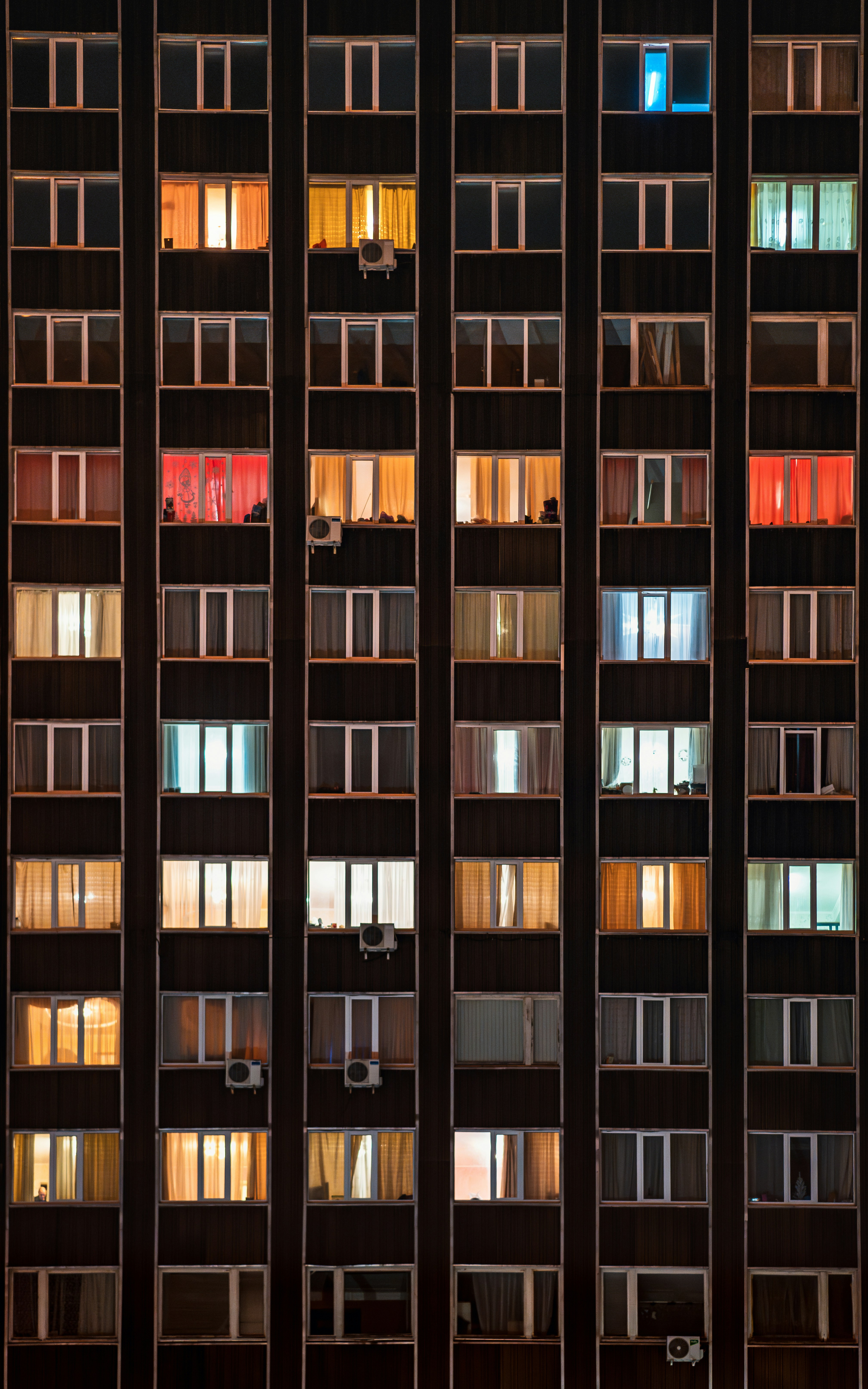 A tall building with many windows lit up at night photo – Free Texture ...