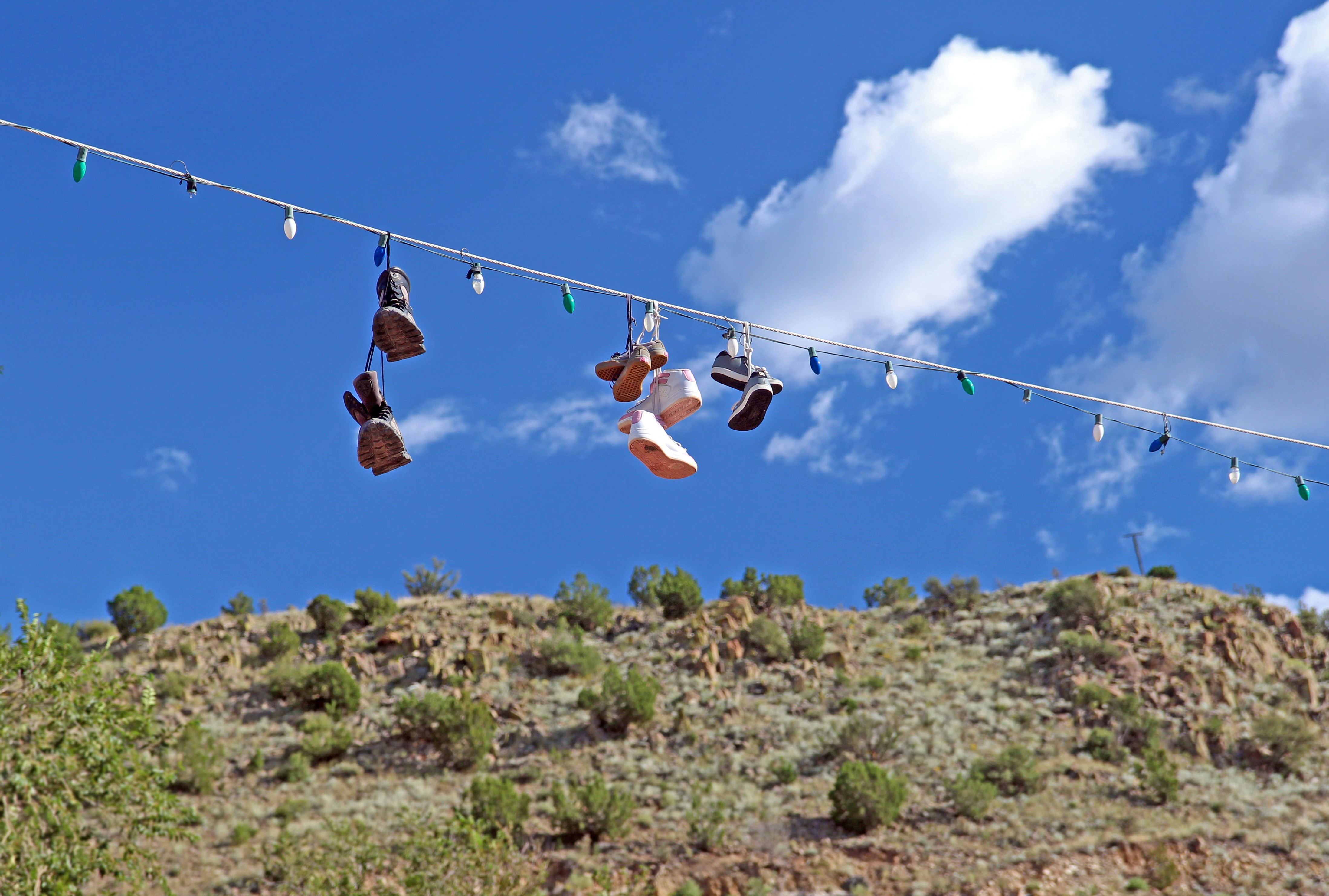 A line of shoes hanging from a clothes line photo – Free Boots Image on ...