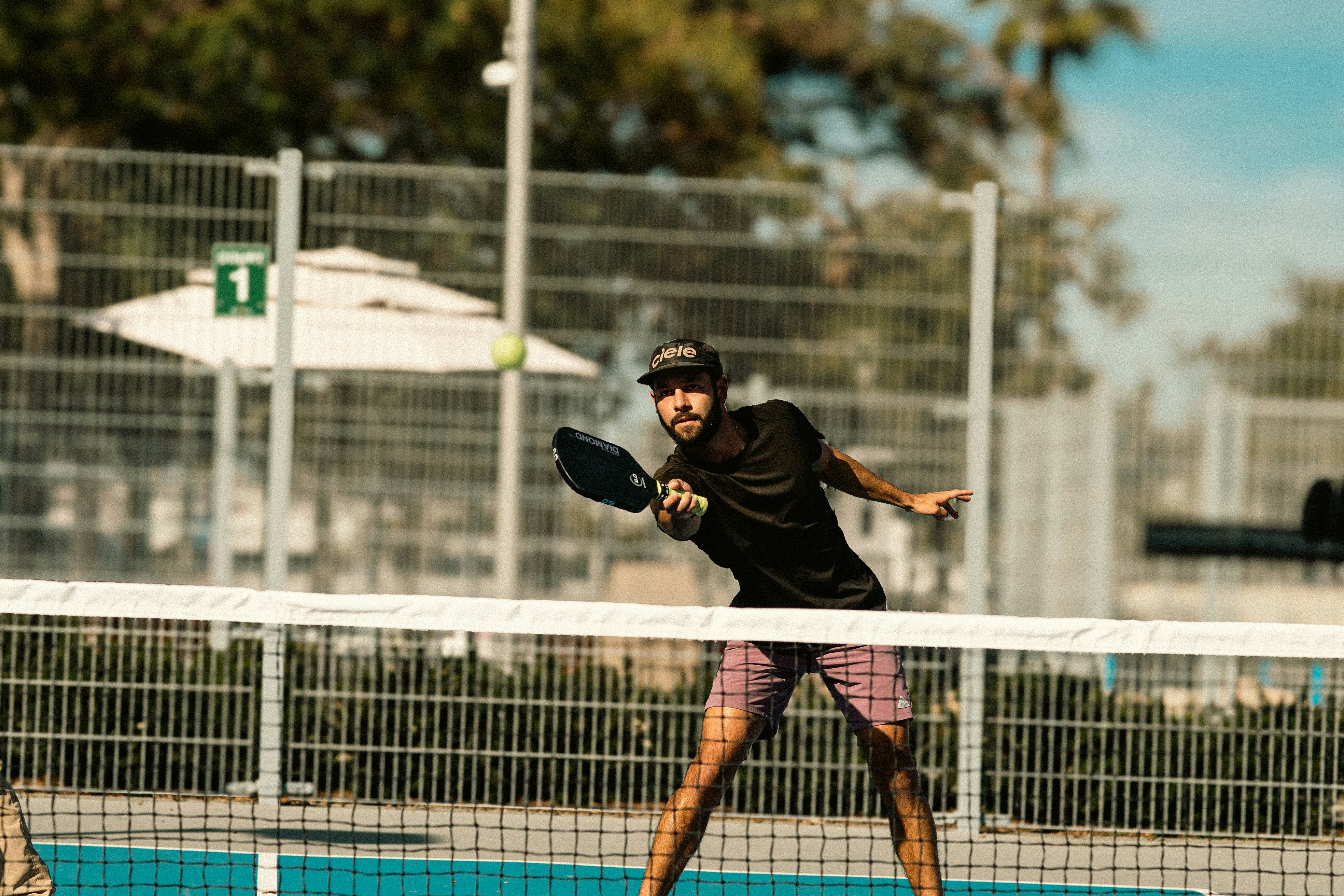 A man holding a tennis racquet on top of a tennis court photo – Free ...