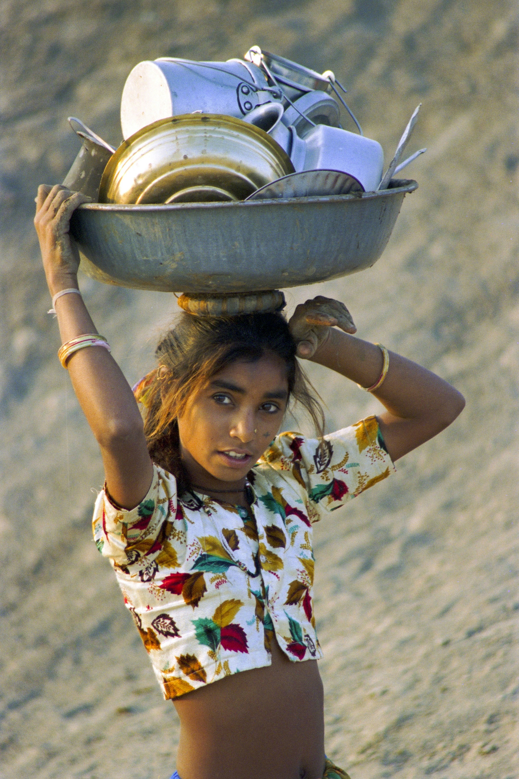 Balanced Burden: A Girl Carries a Kitchenful of Silver on Her Head