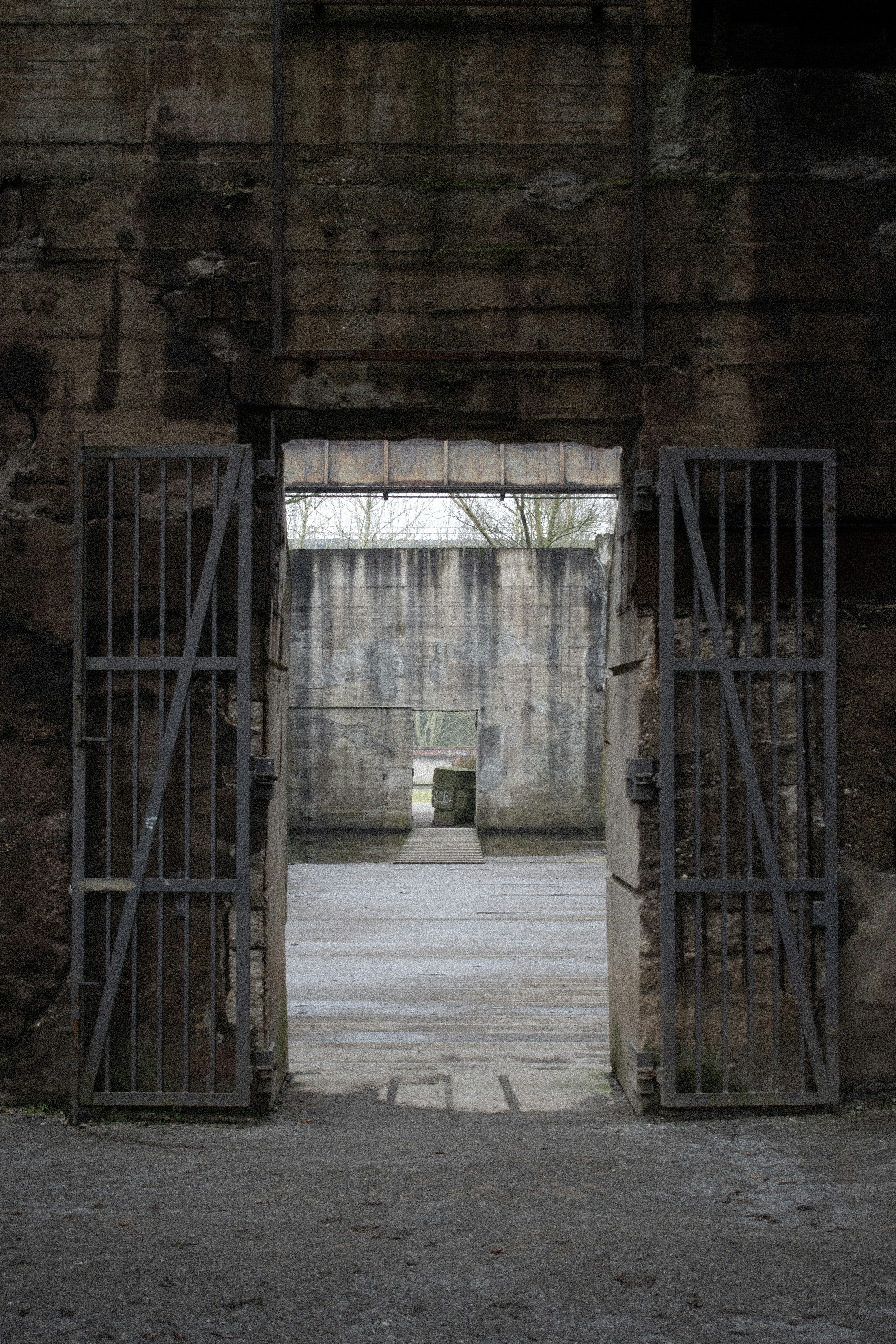 Echoes Beyond the Iron Gate: A Corridor of Concrete Arches Framing Light