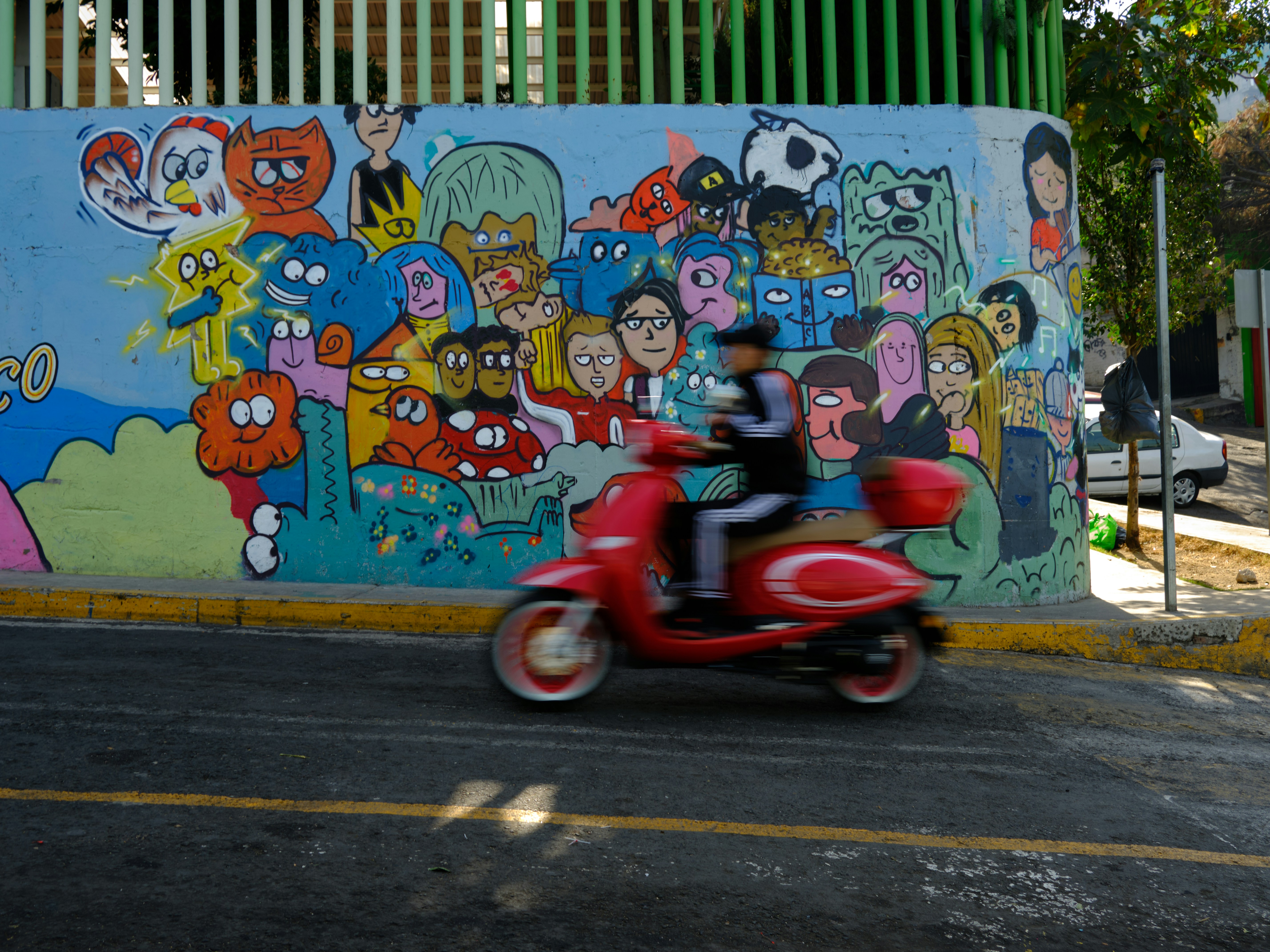 Red Scooter in Front of a Colorful Wall Mural