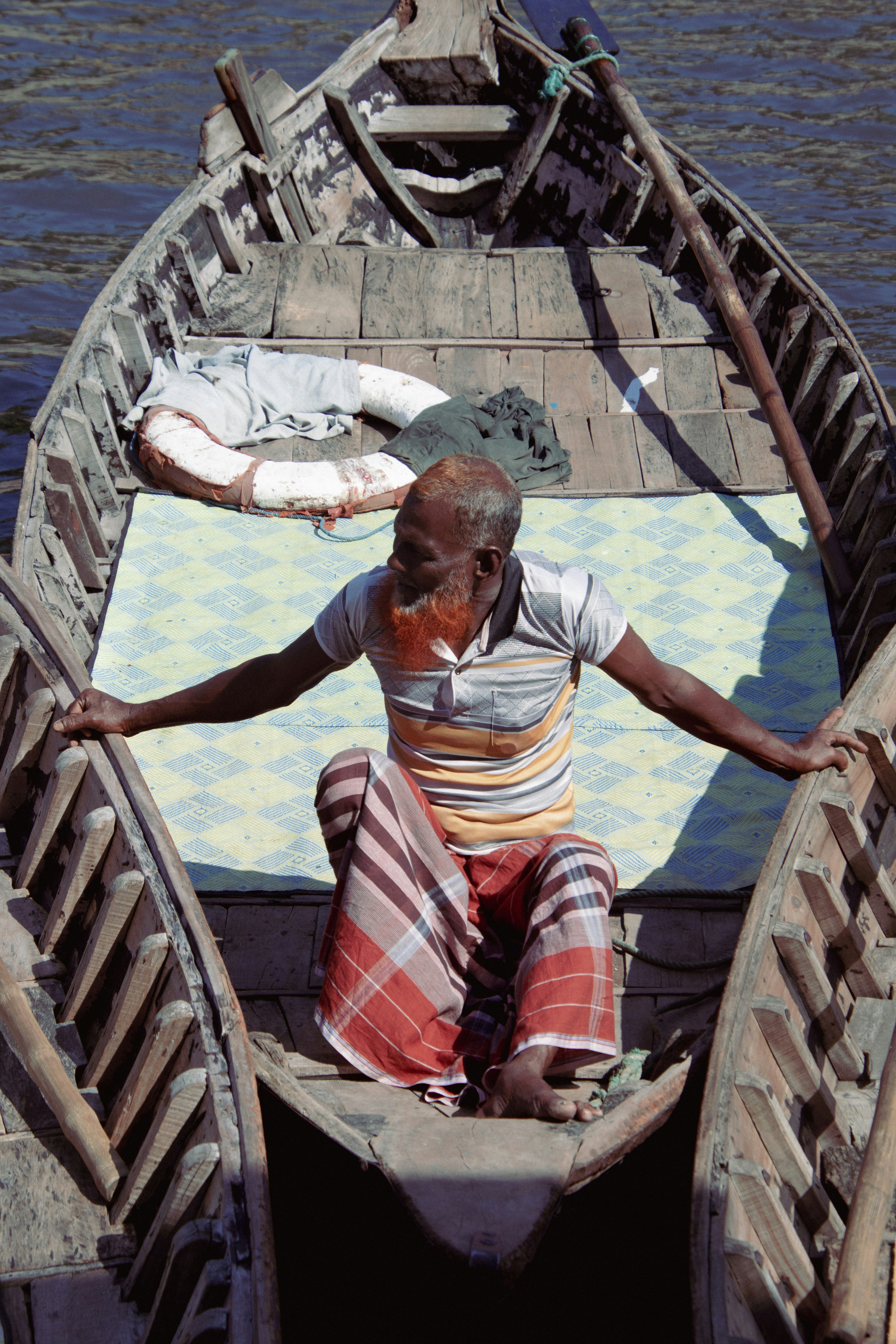 Bearded Navigator in a Weathered Dinghy with a Checker-Pattern Mat