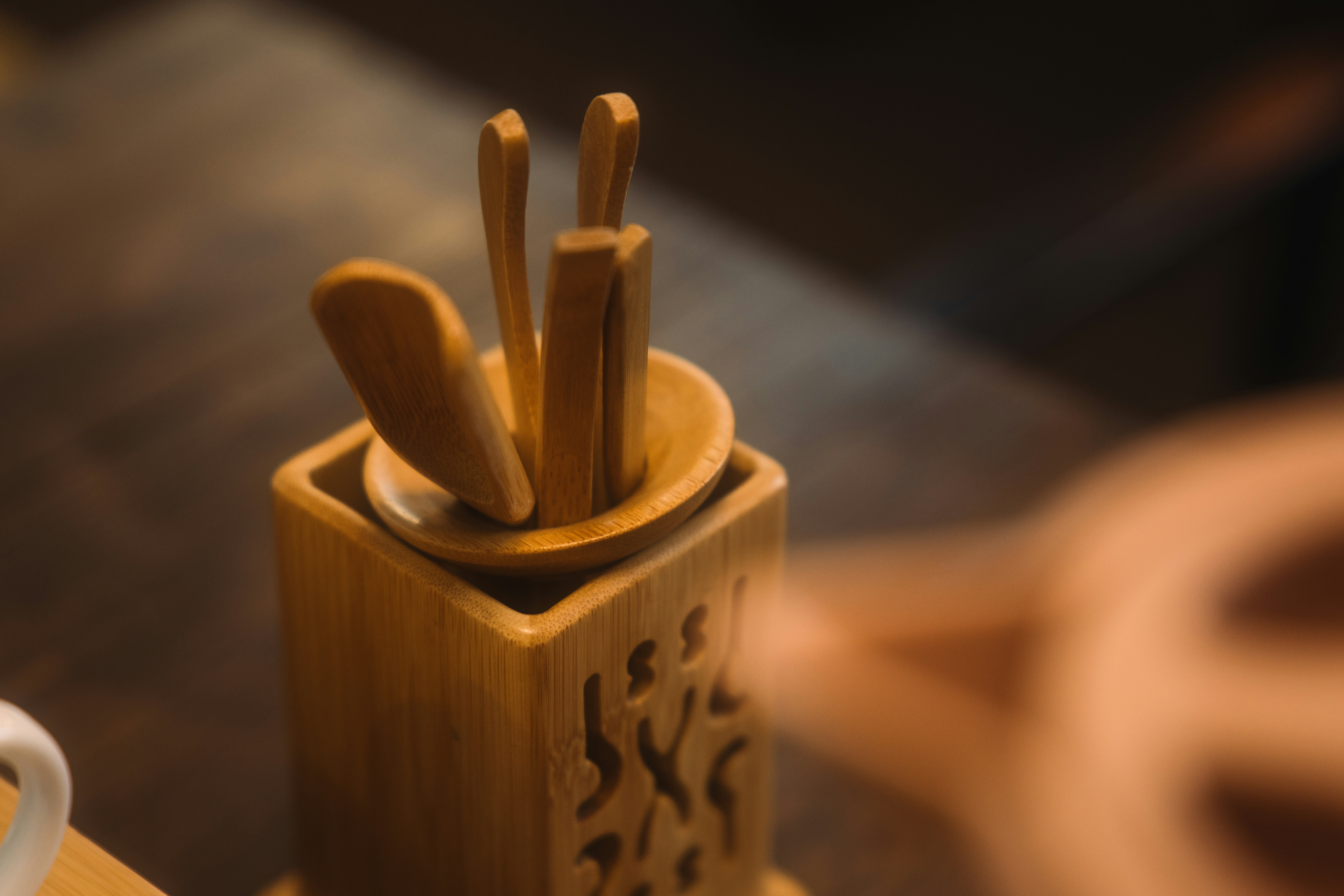 Warmth in Focus: Spindle Spoons Rising from a Bamboo Utensil Holder