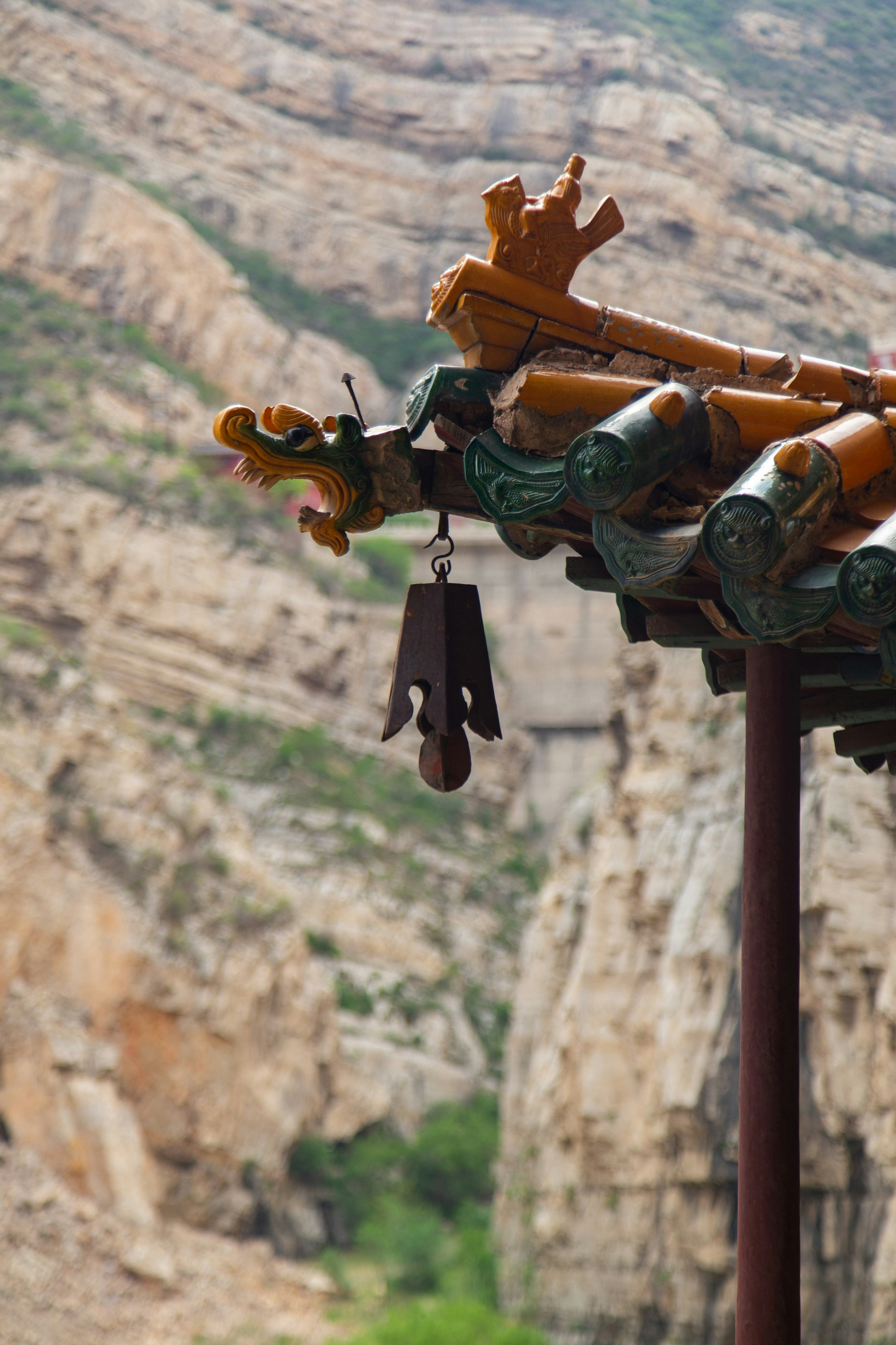 Dragon's Crest on a Tiled Roof Framed by a Weathered Canyon