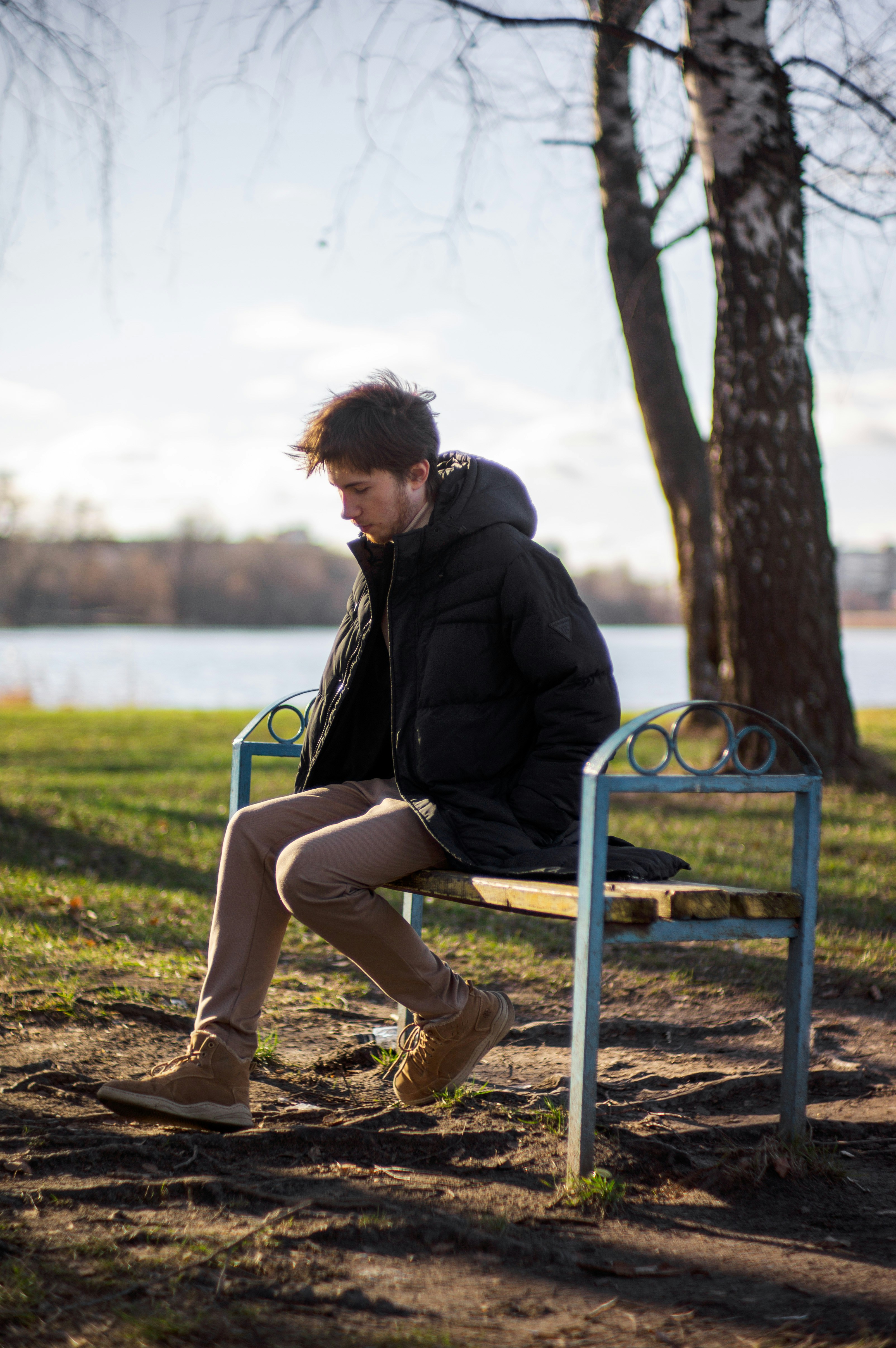 A man sitting on a bench in a park photo – Free Sumy Image on Unsplash