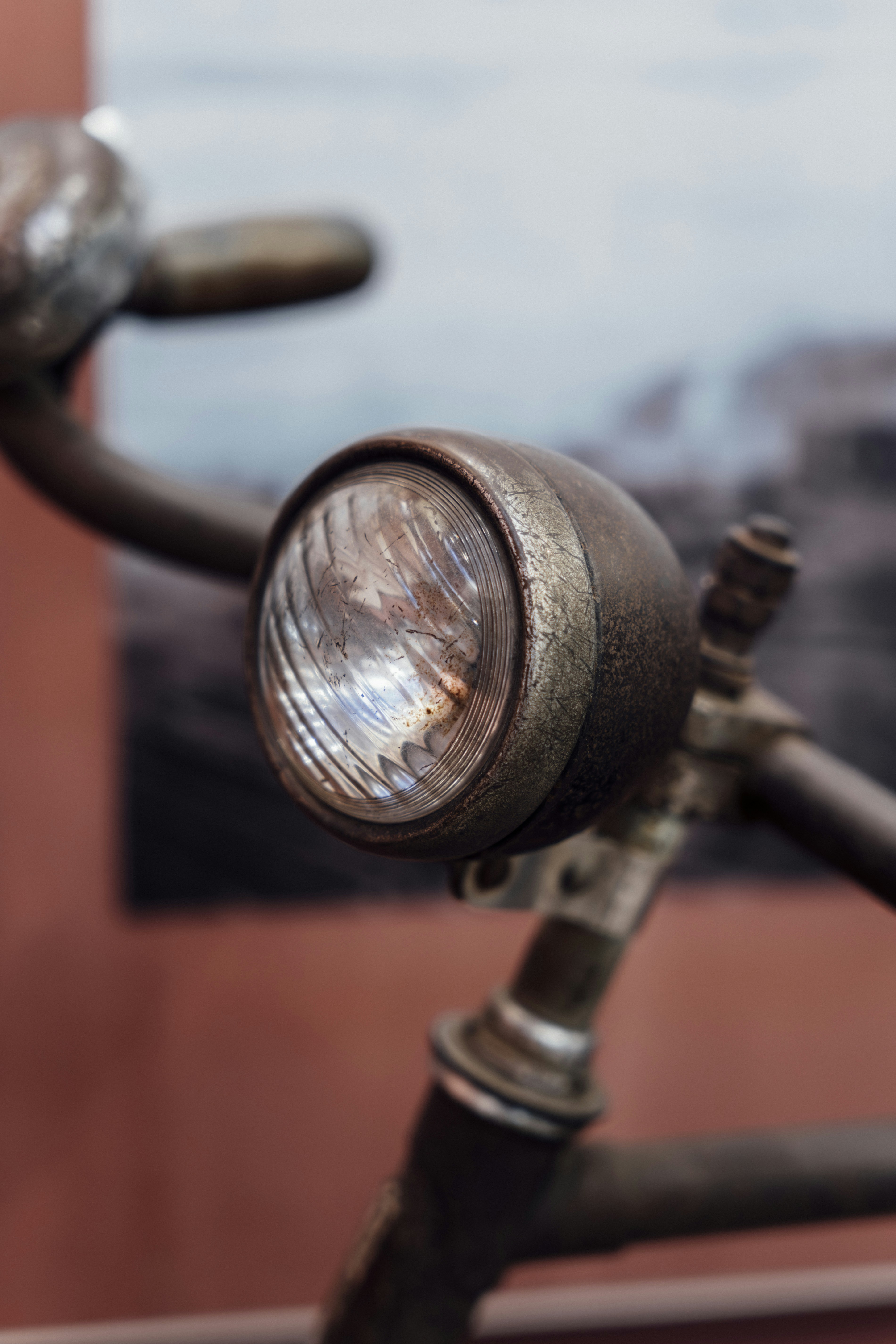 Rust-Glazed Beacon: A Close-Up of a Weathered Motorcycle Headlight