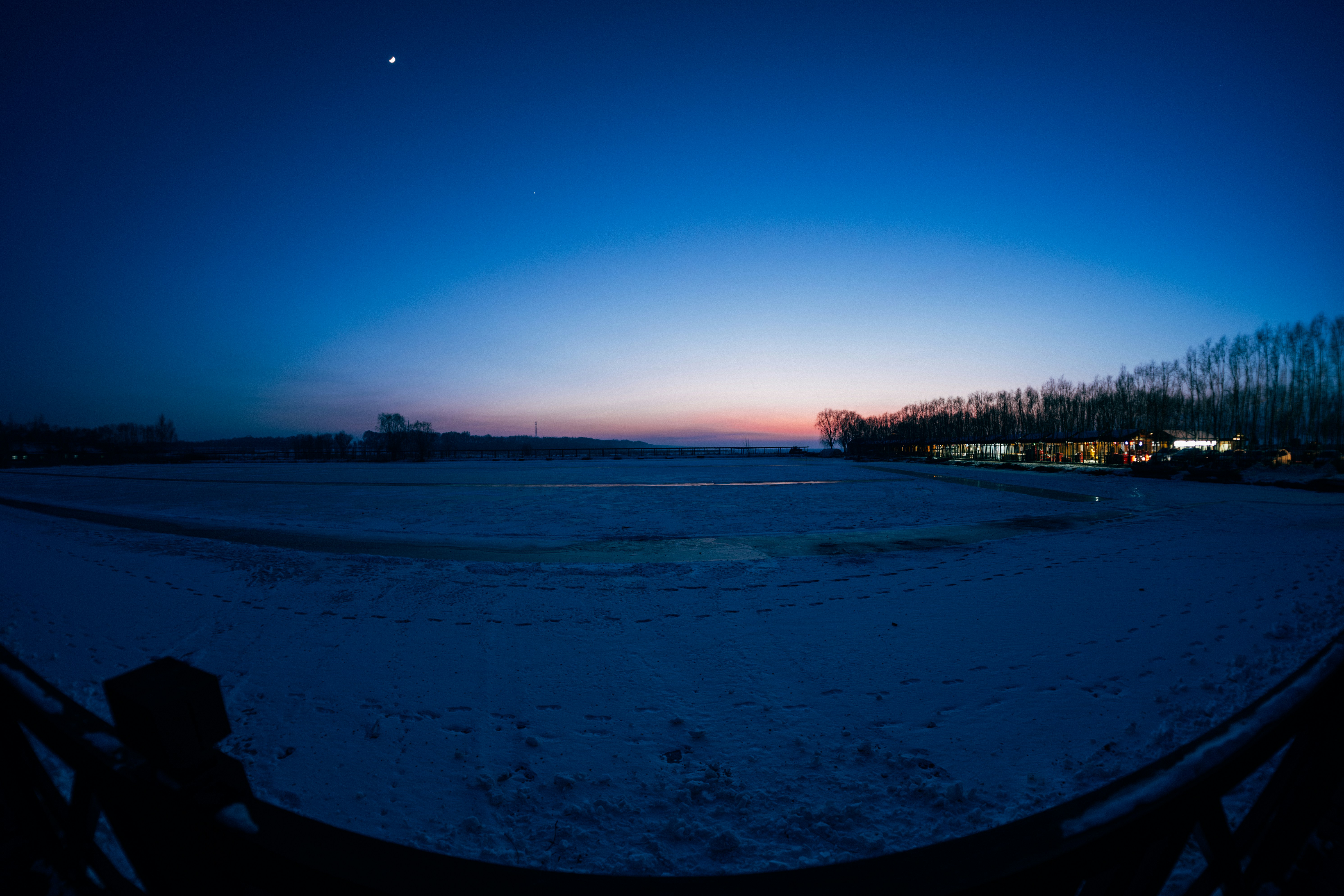 A snow covered field at night with the moon in the sky photo – Free ...