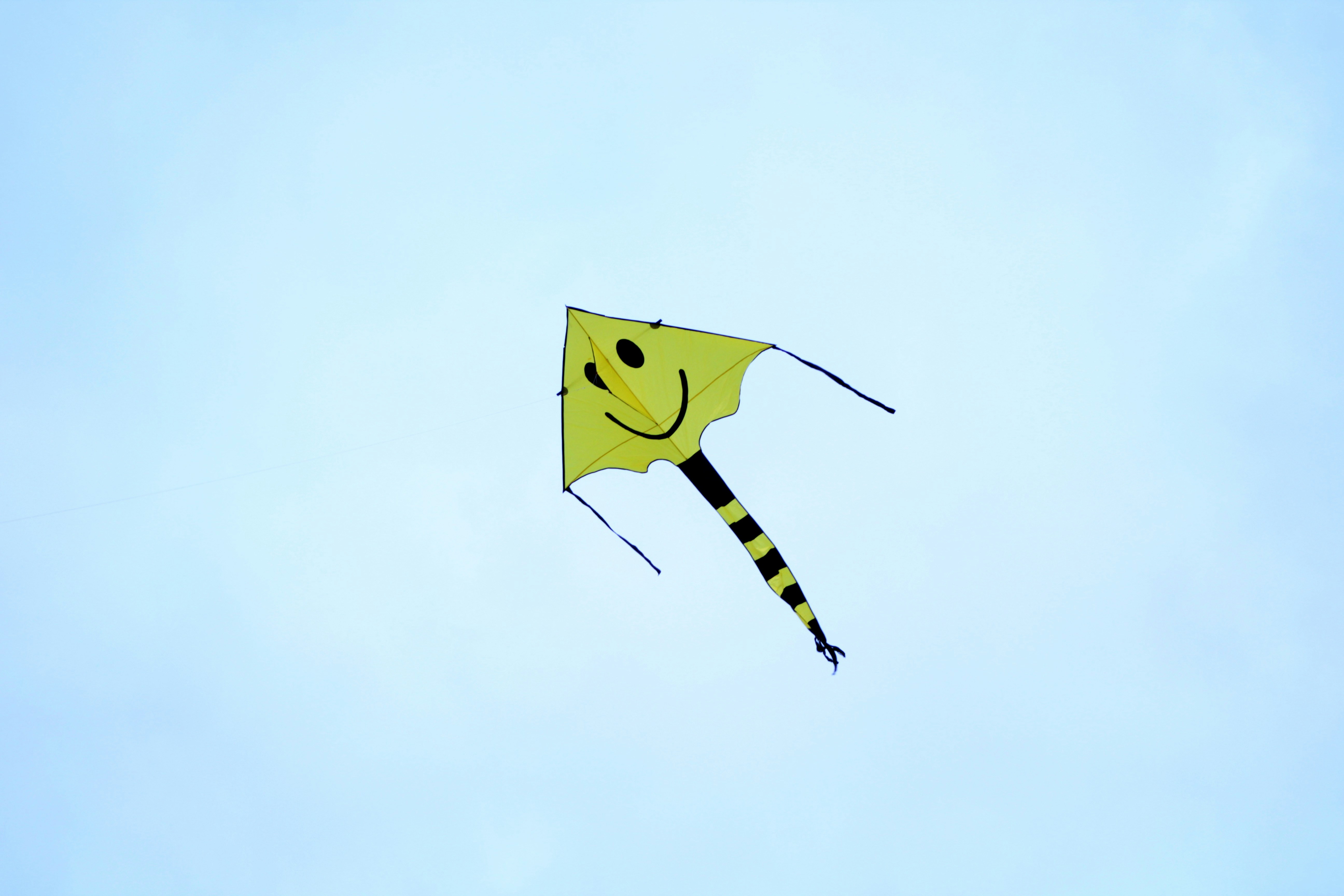 A yellow kite with a smiley face on it photo – Free Smiley face Image ...