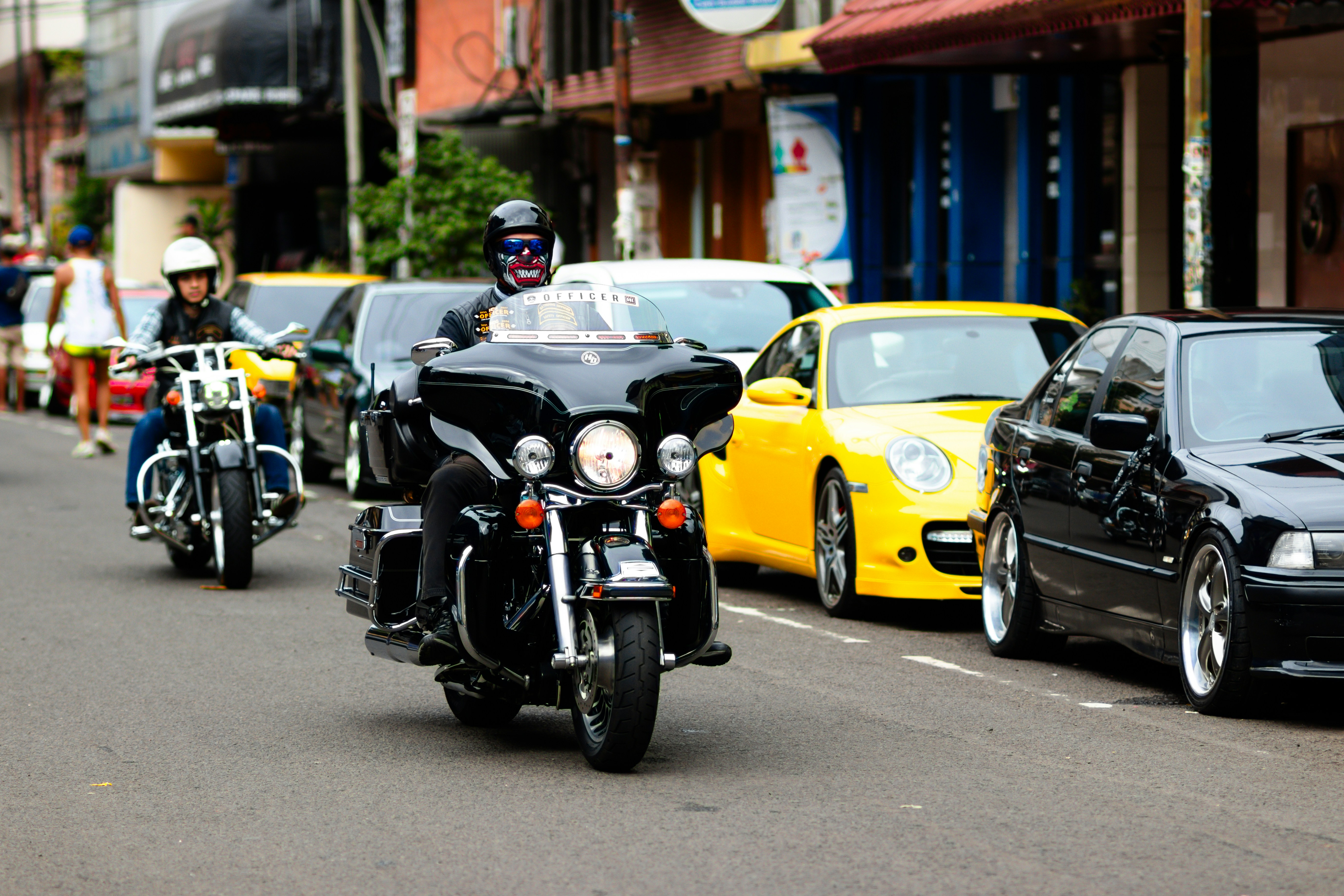 A group of people riding motorcycles down a street photo – Free Blok m ...